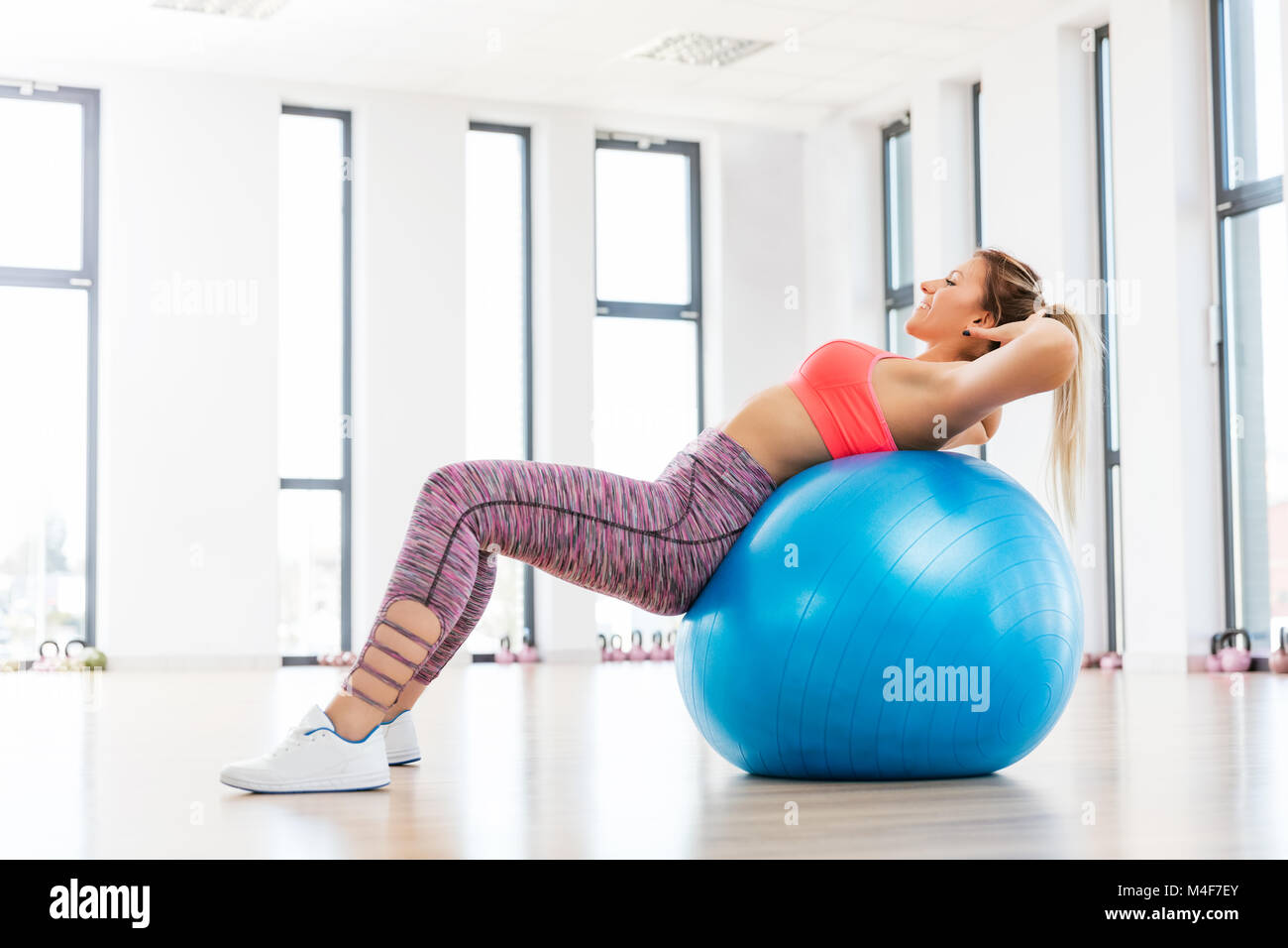Young woman training with fitball at fitness club Stock Photo - Alamy