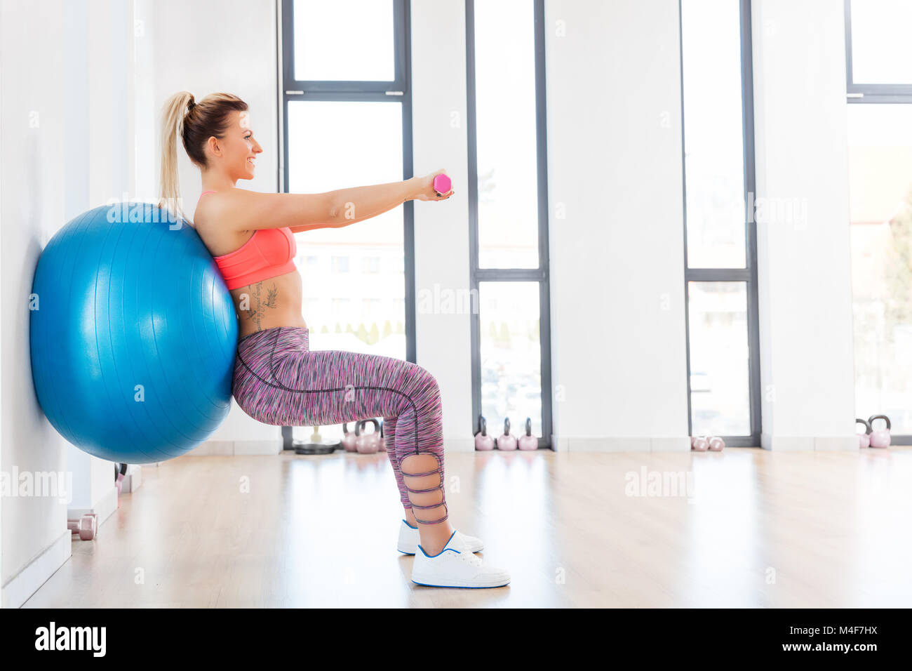 Young woman training with fitball at fitness club Stock Photo - Alamy