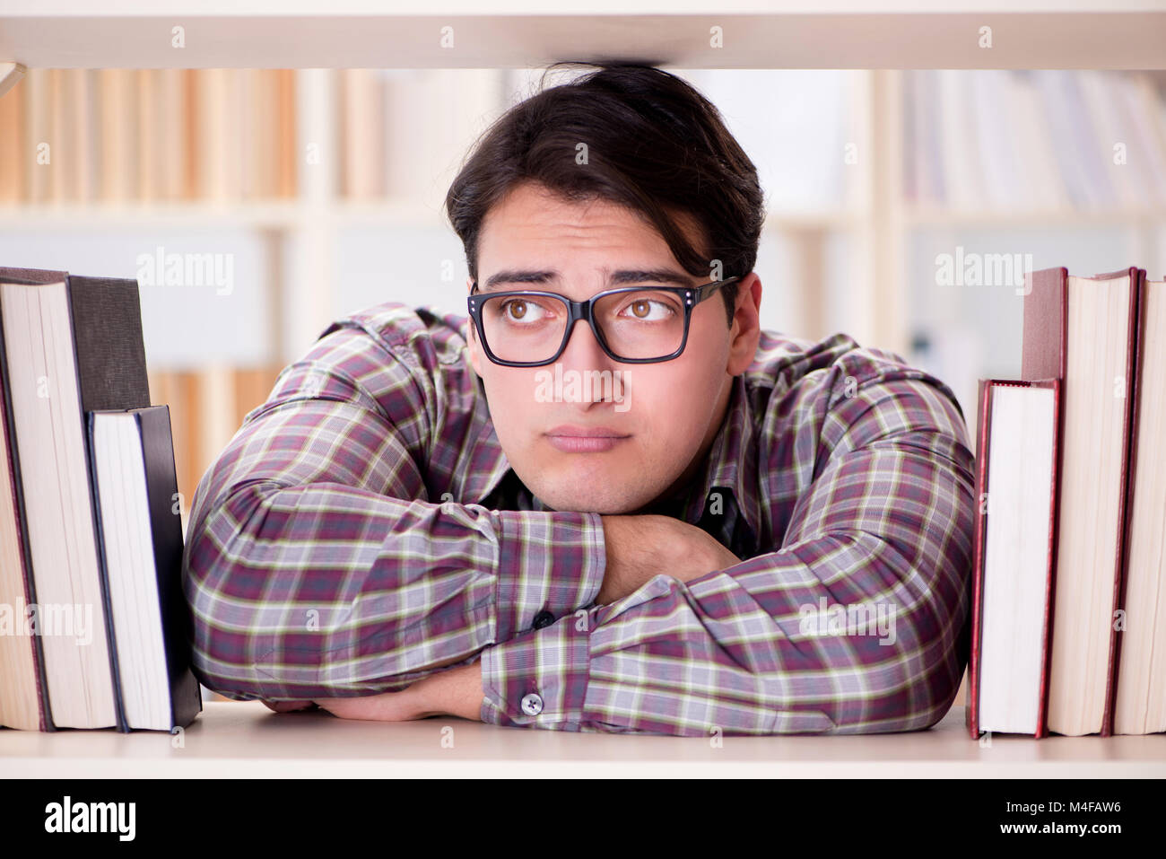 Young student looking for books in college library Stock Photo - Alamy