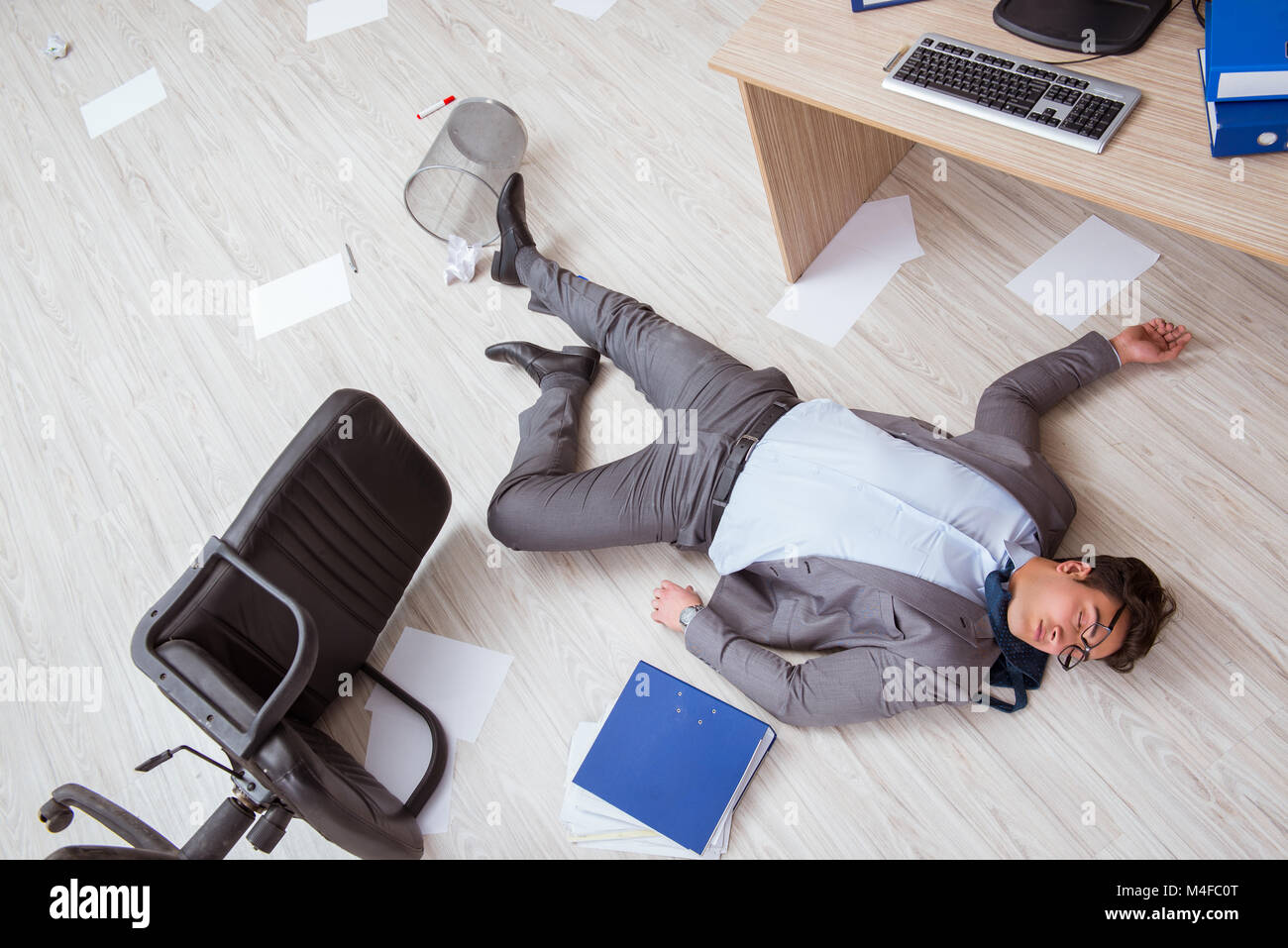 Businessman dead on the office floor Stock Photo - Alamy