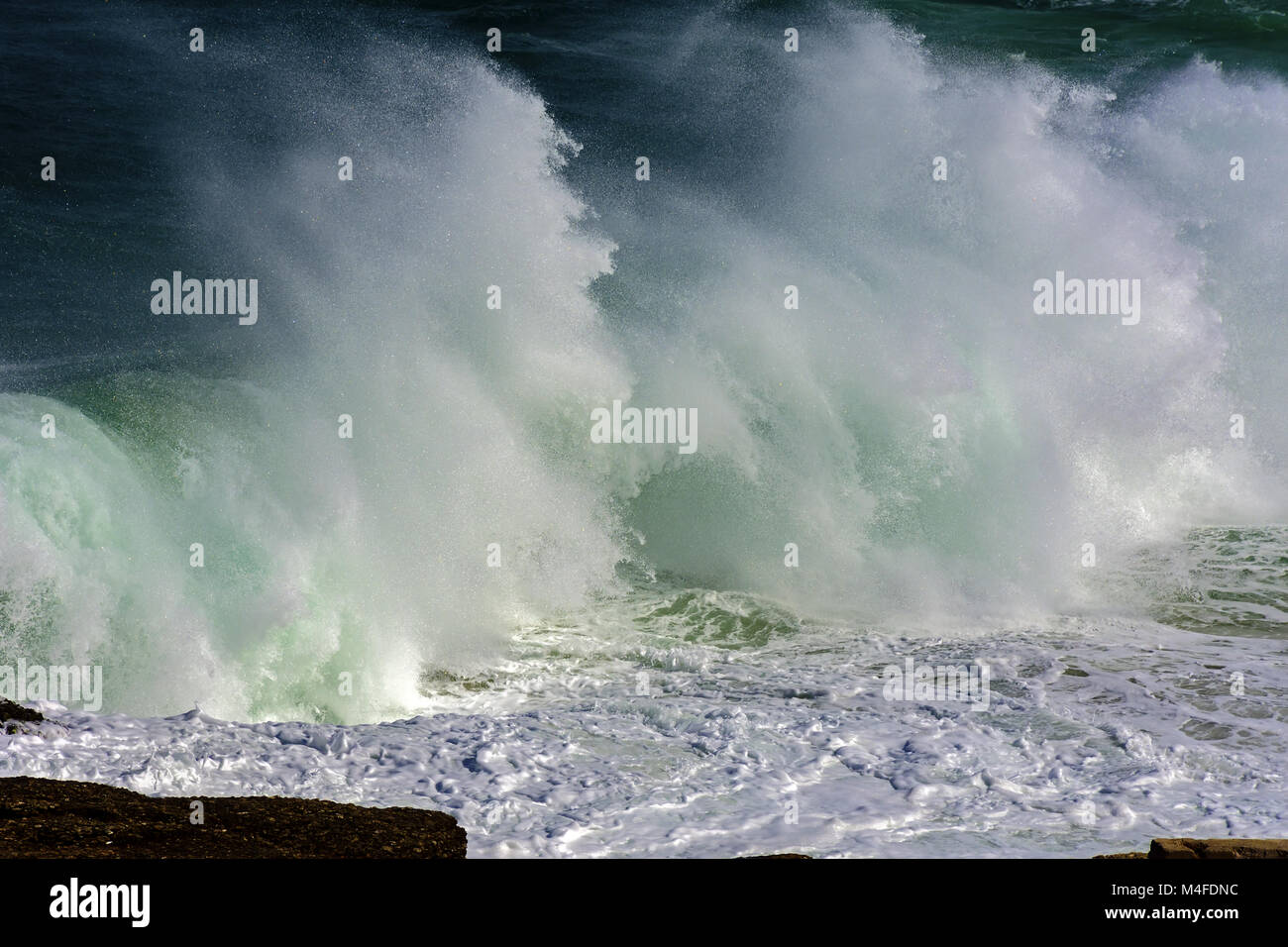 Storm wave crashing on the rocks Stock Photo - Alamy