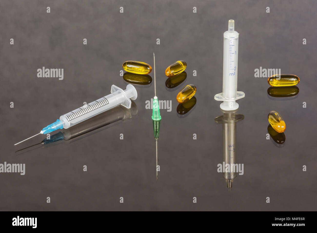 Two medical syringes with needles and capsules with medicine Stock ...