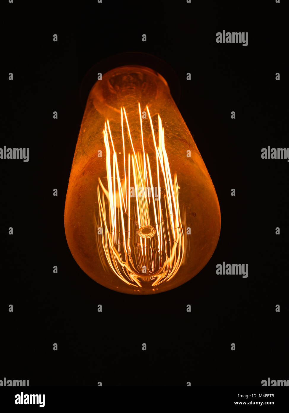 Close up one modern design electric light bulb over dark black ...