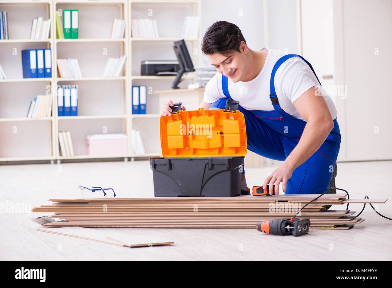 Young worker working on floor laminate tiles Stock Photo - Alamy