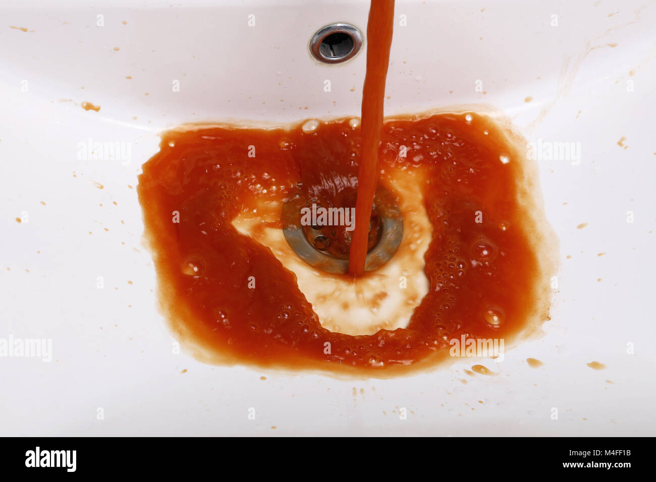 Close up dirty rusty brown polluted water flowing from tap in bathroom ...