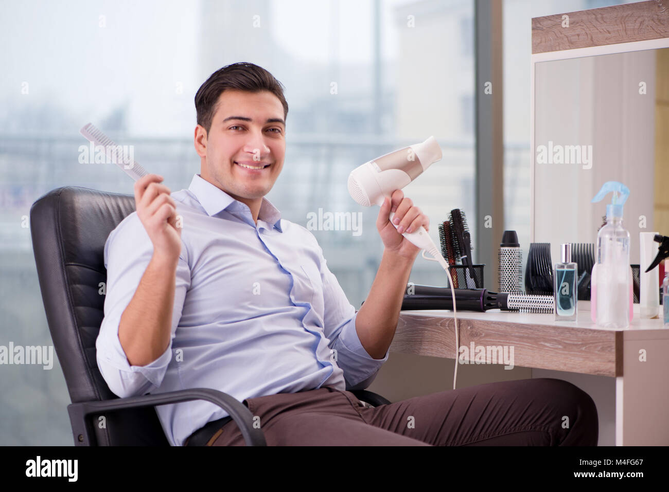 Handsome man in hair salon doing haircut Stock Photo - Alamy