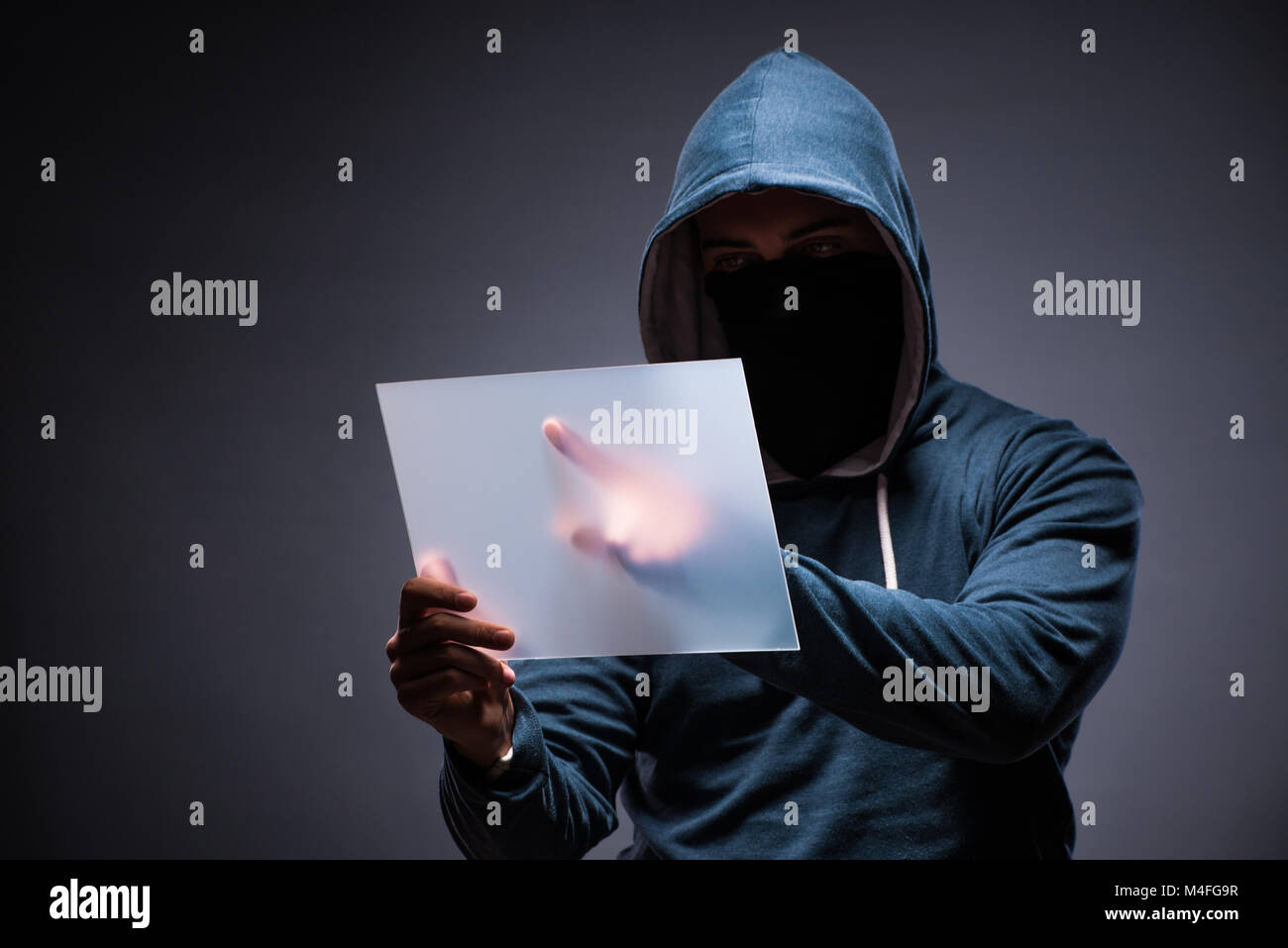 Hacker working on tablet in dark Stock Photo - Alamy