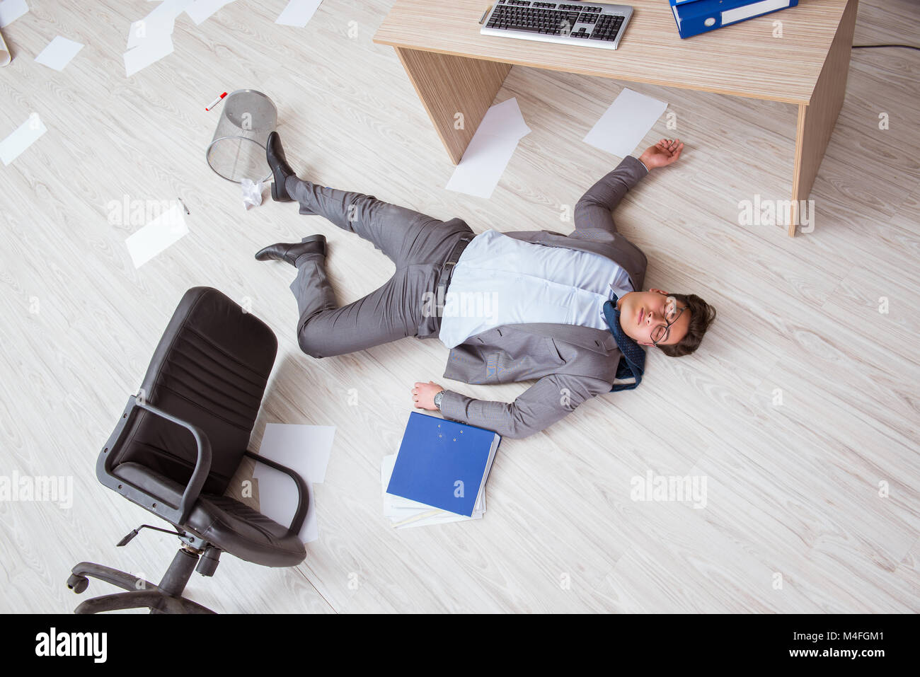 Businessman dead on the office floor Stock Photo - Alamy