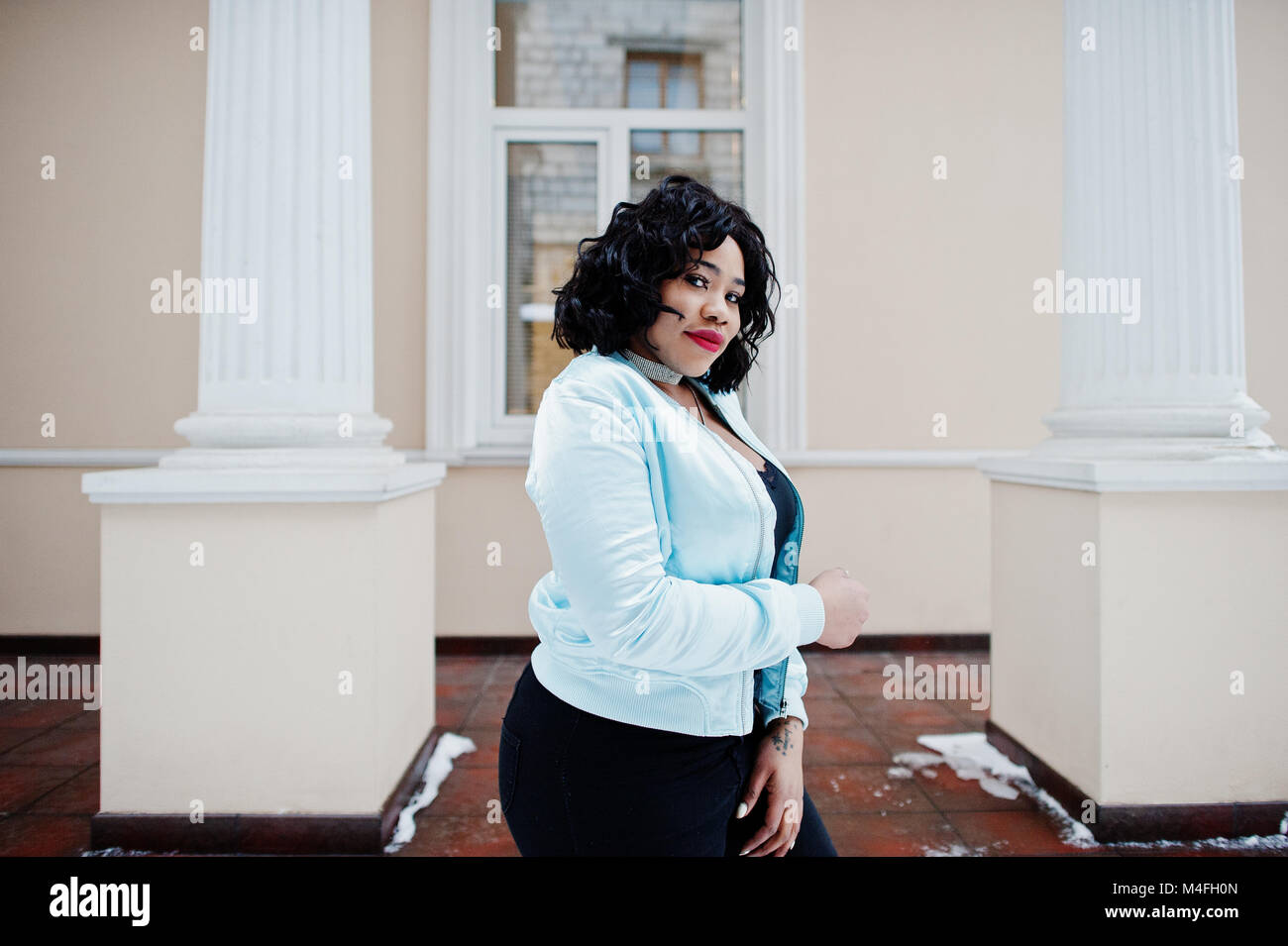 Stylish african american plus size model at streets of city on winter ...
