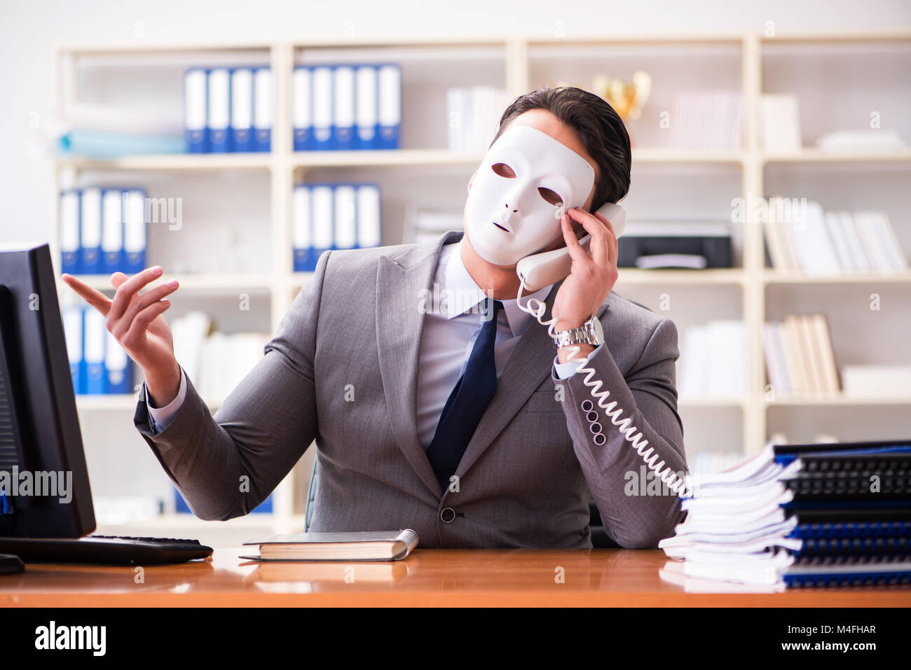 Businessman with mask in office hypocrisy concept Stock Photo - Alamy