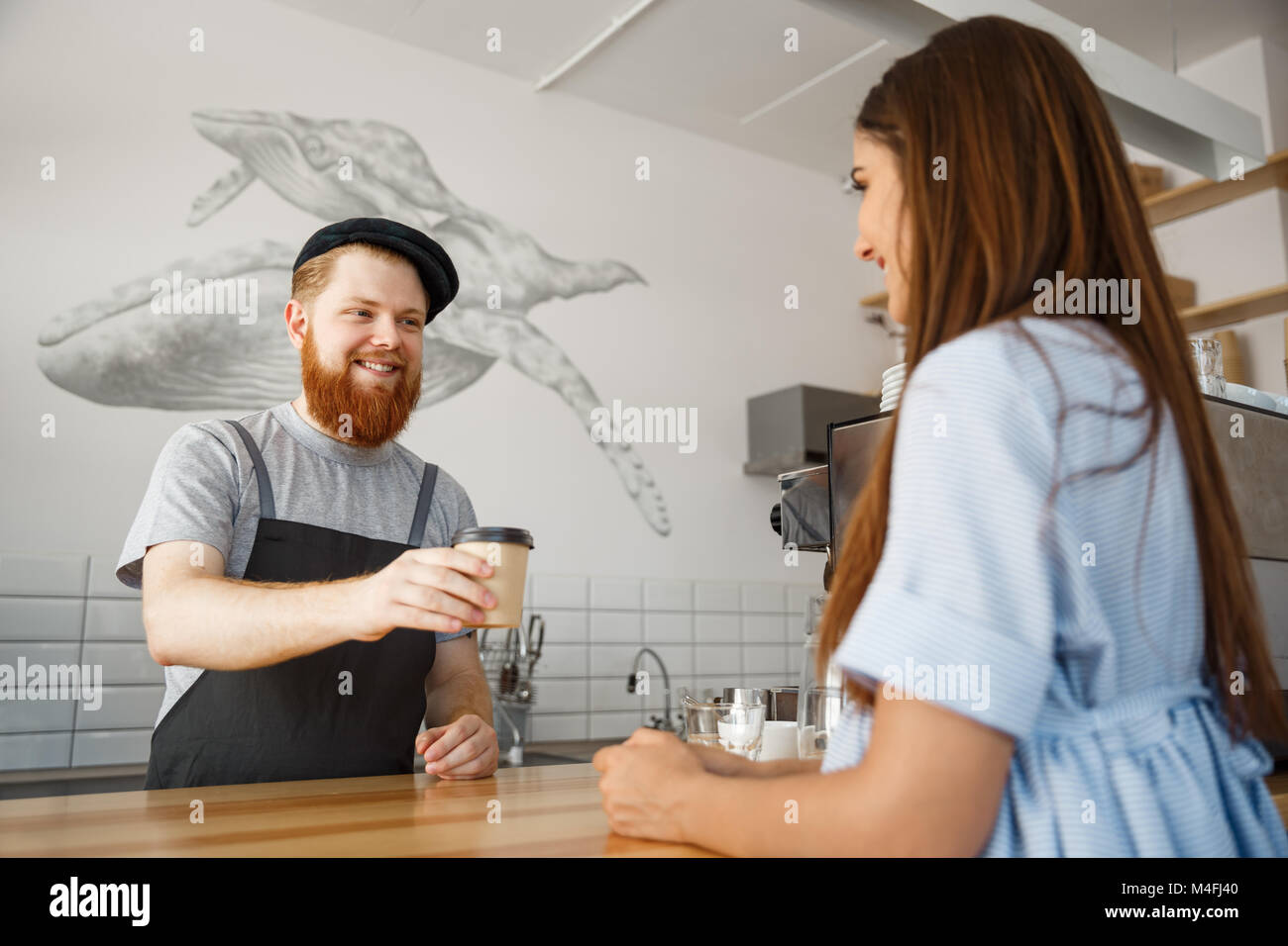 Coffee Business Concept - young beared handsome barista talking and ...