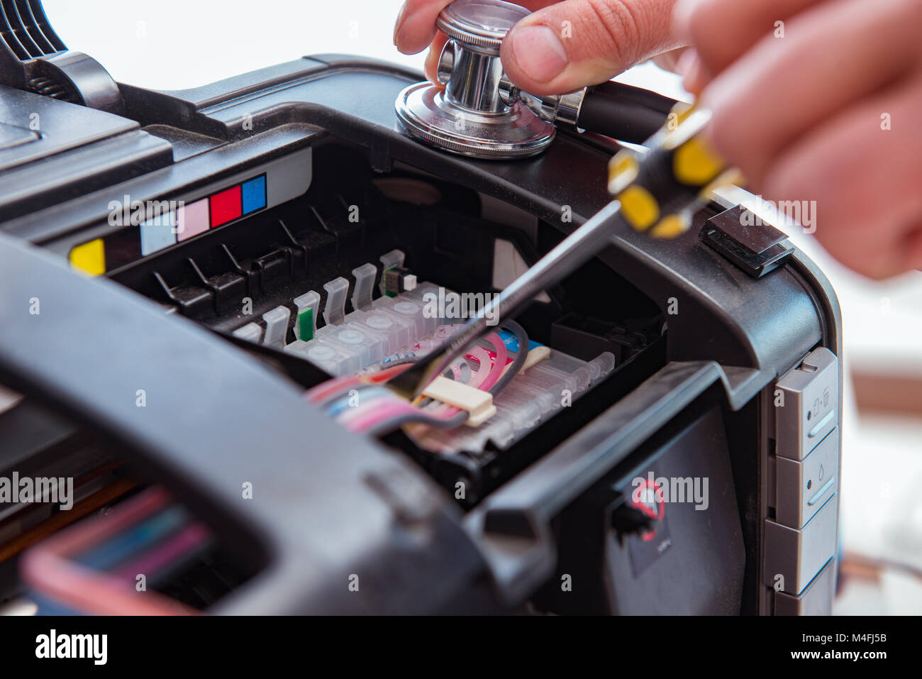 Repairman repairing broken color printer Stock Photo - Alamy