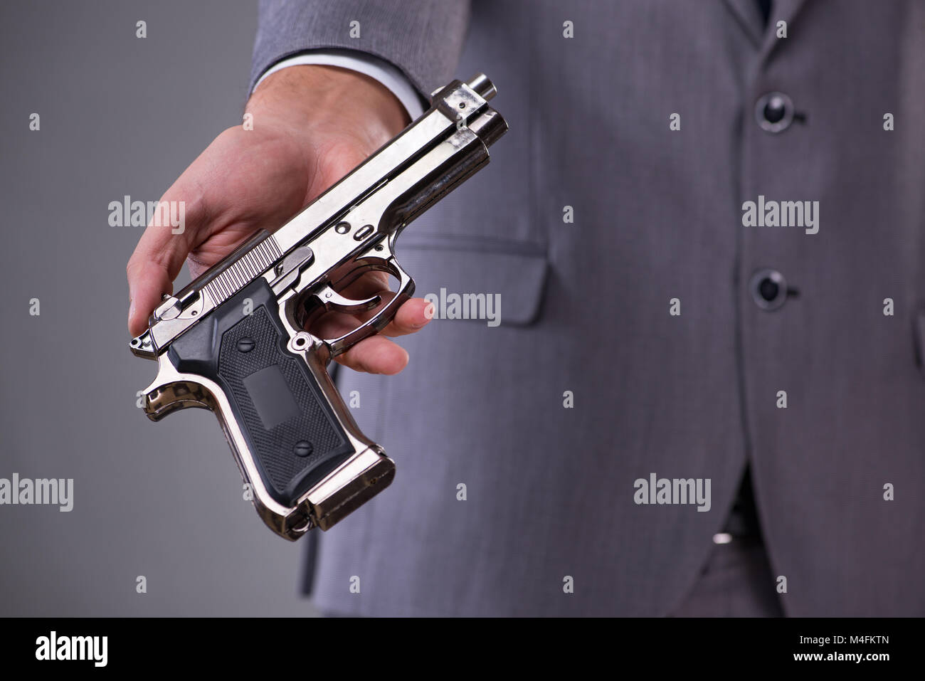Businessman pulling the gun out of pocket Stock Photo - Alamy