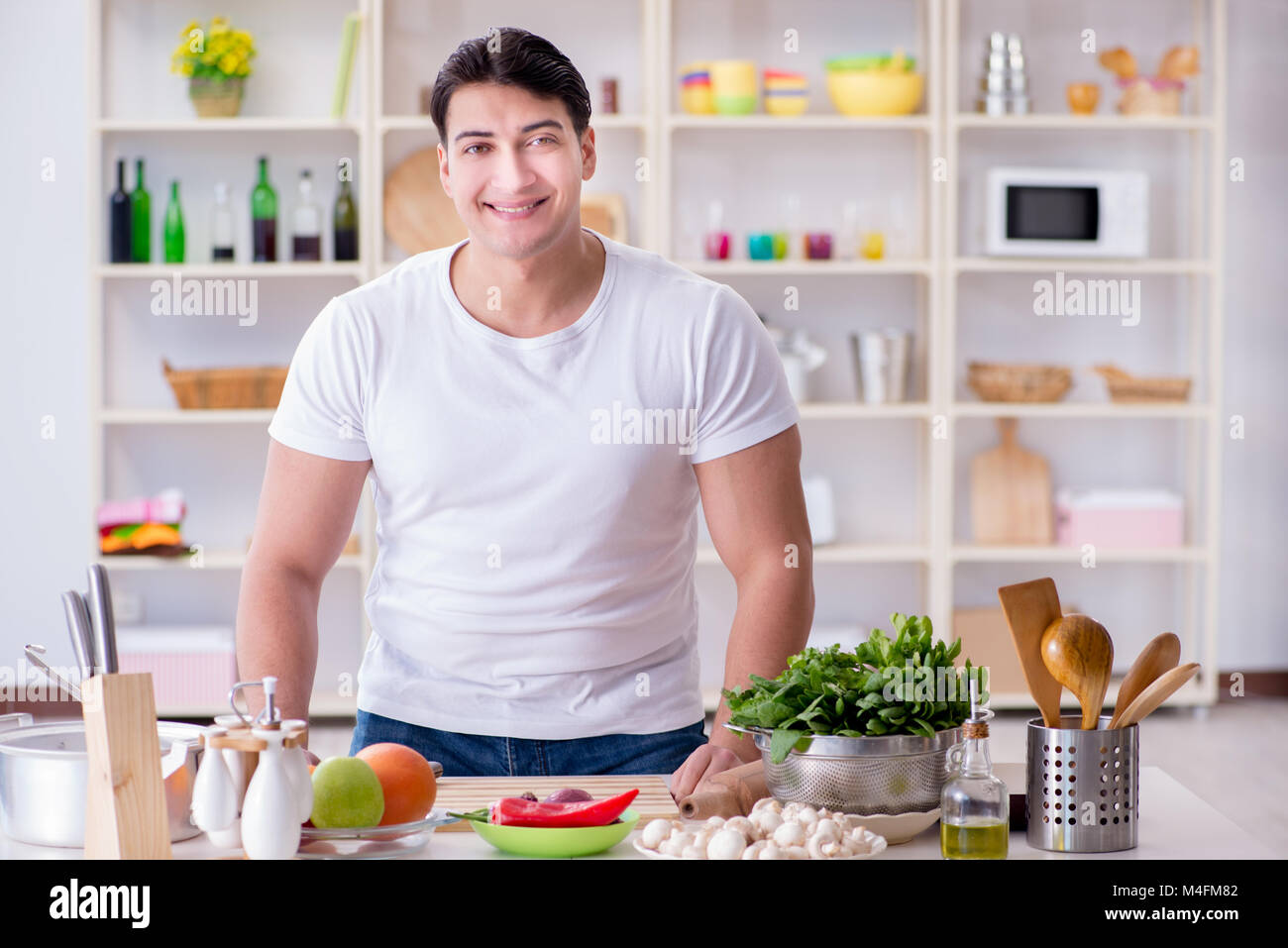 Young male cook working in the kitchen Stock Photo - Alamy