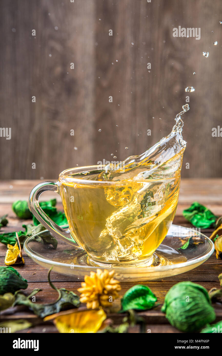 Green tea in transparent mug with spill dropwise Stock Photo - Alamy