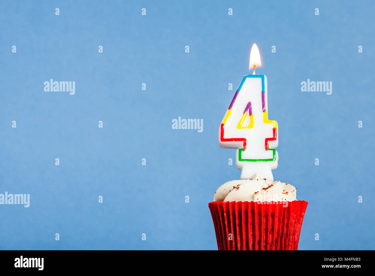 Number 4 birthday candle in a cupcake against a blue background Stock ...