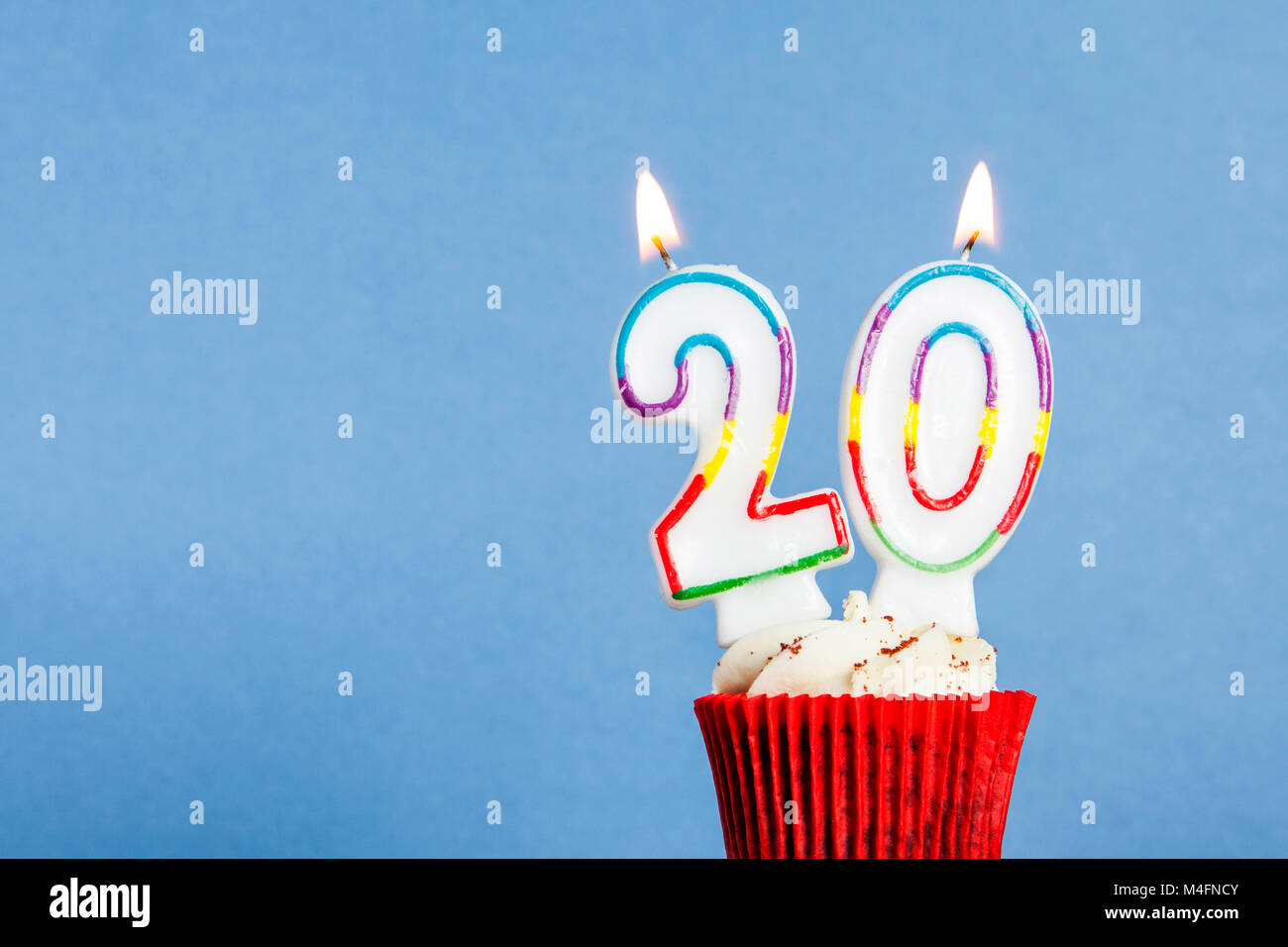 Number 20 birthday candle in a cupcake against a blue background Stock ...
