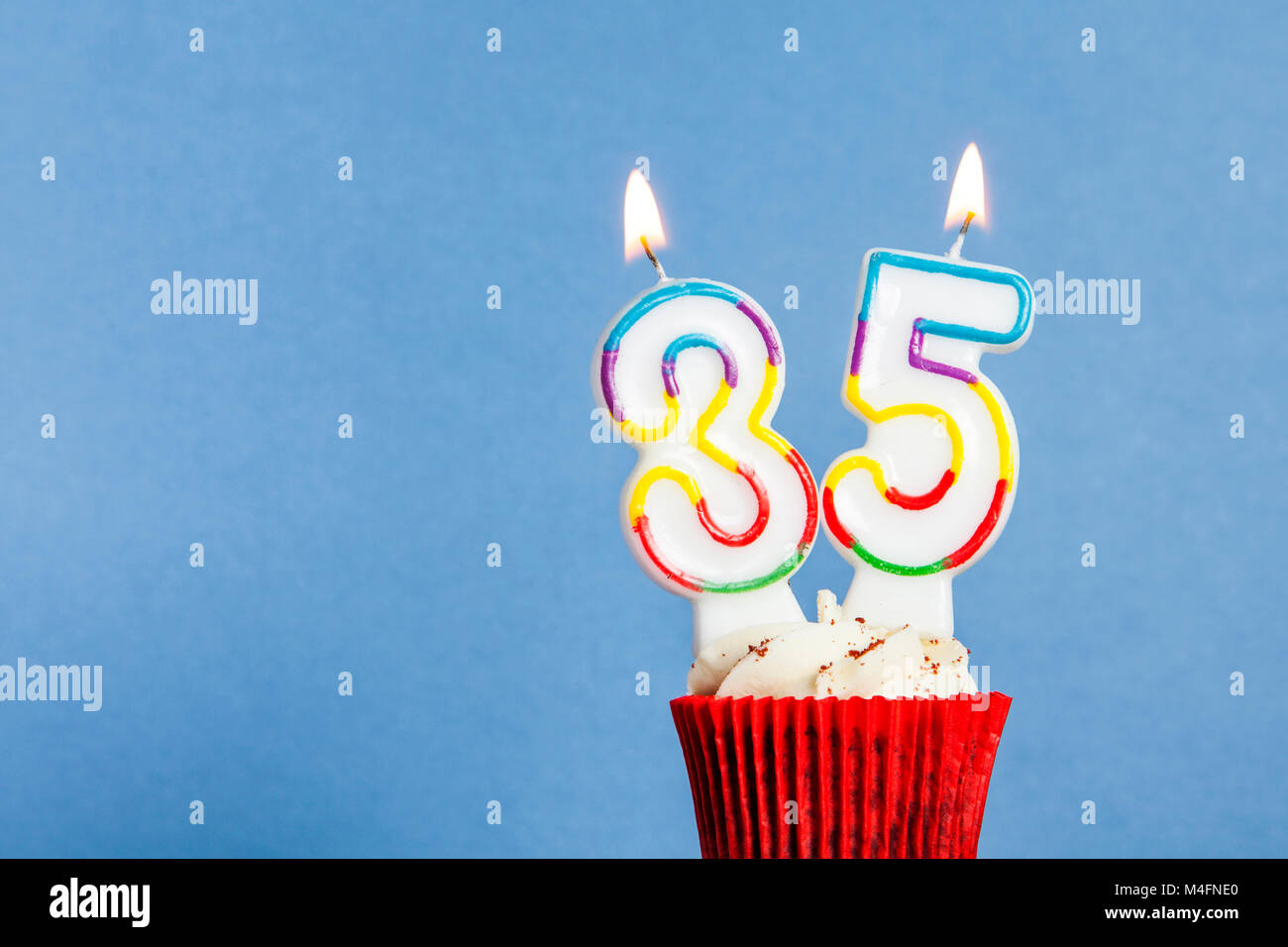 Number 35 birthday candle in a cupcake against a blue background Stock ...