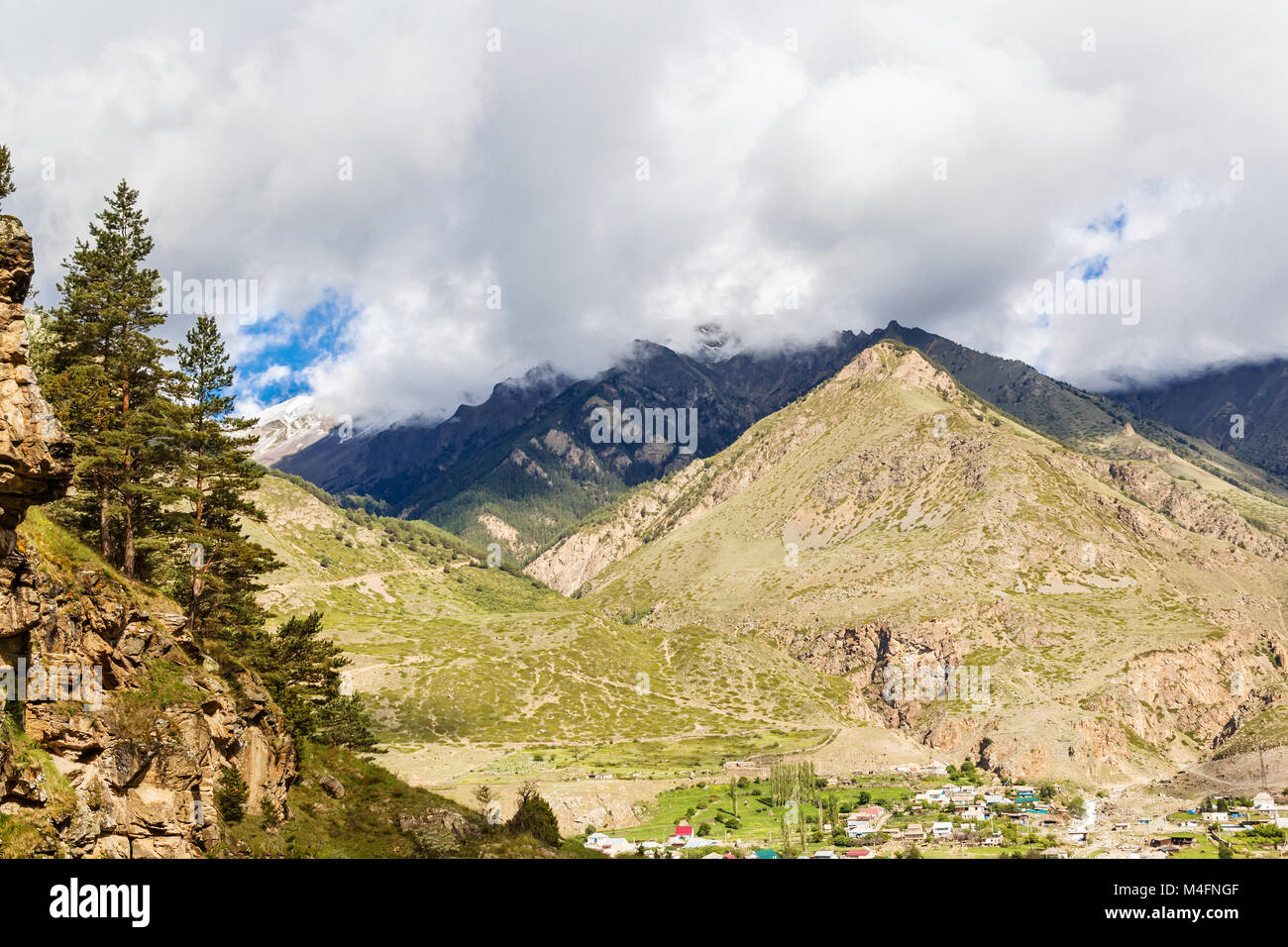 Landscape with a small village at the foot of mountains Stock Photo - Alamy