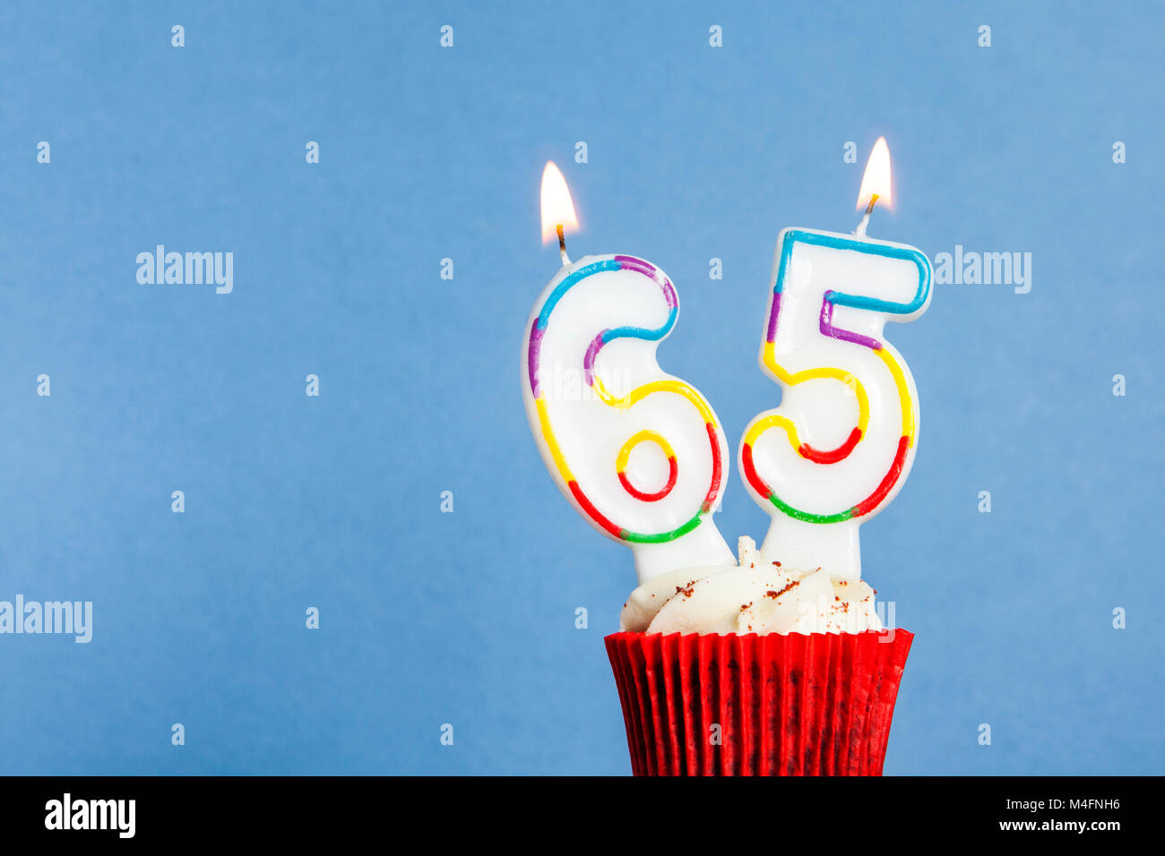 Number 65 birthday candle in a cupcake against a blue background Stock ...