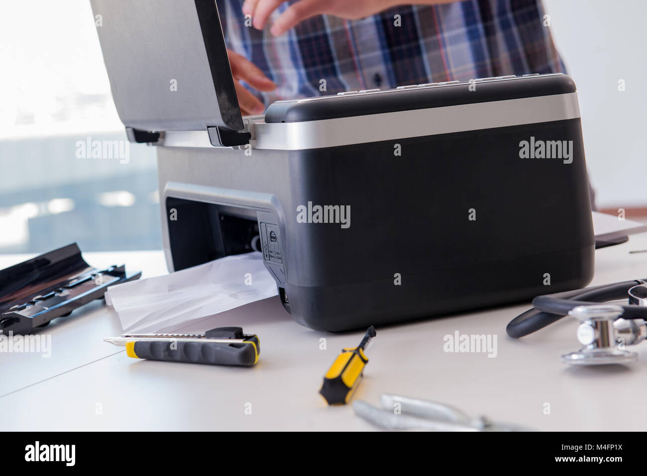 Repairman repairing broken color printer Stock Photo - Alamy