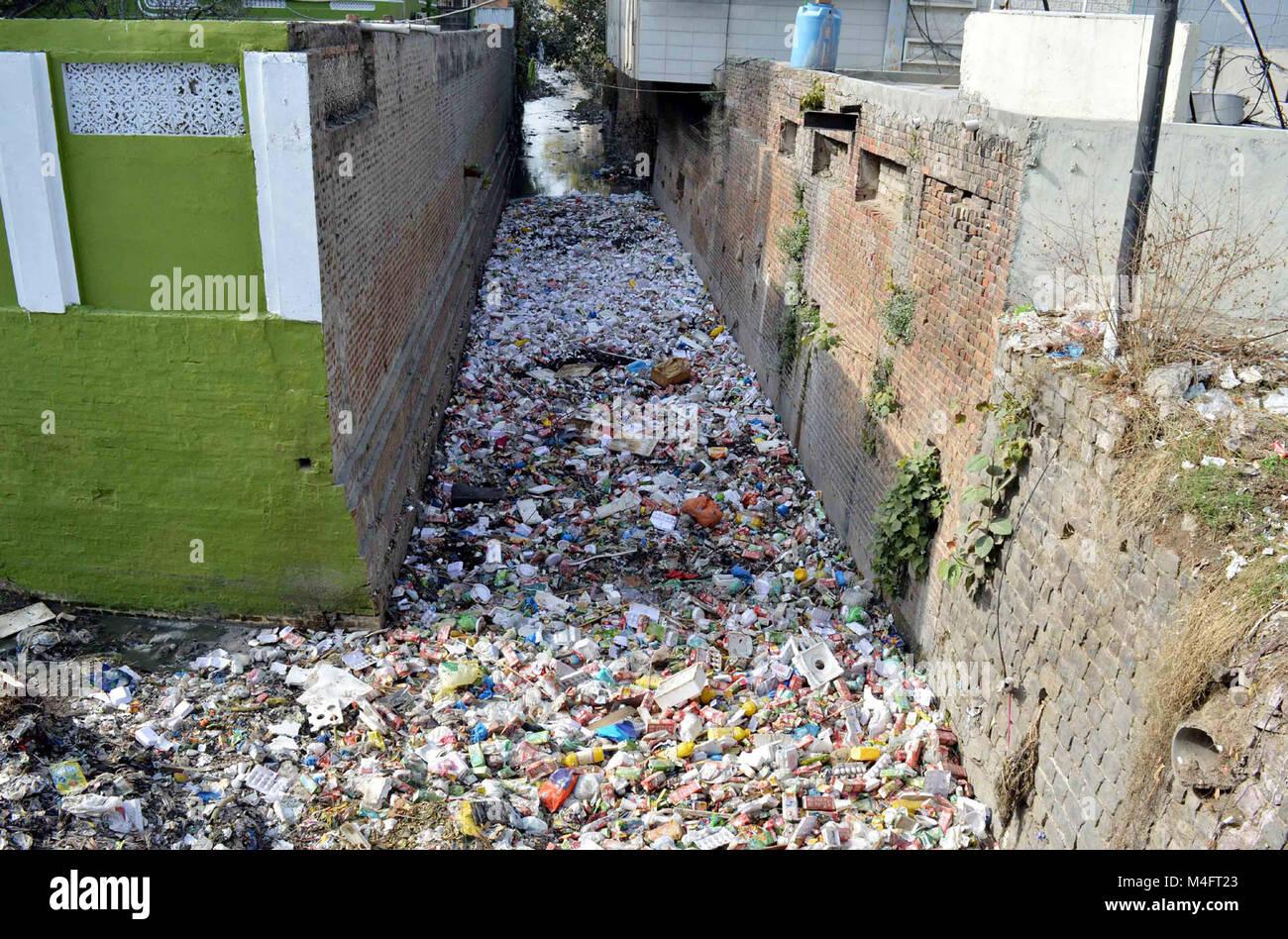 Heap of garbage covered rain drain causing blockage of sewerage water ...