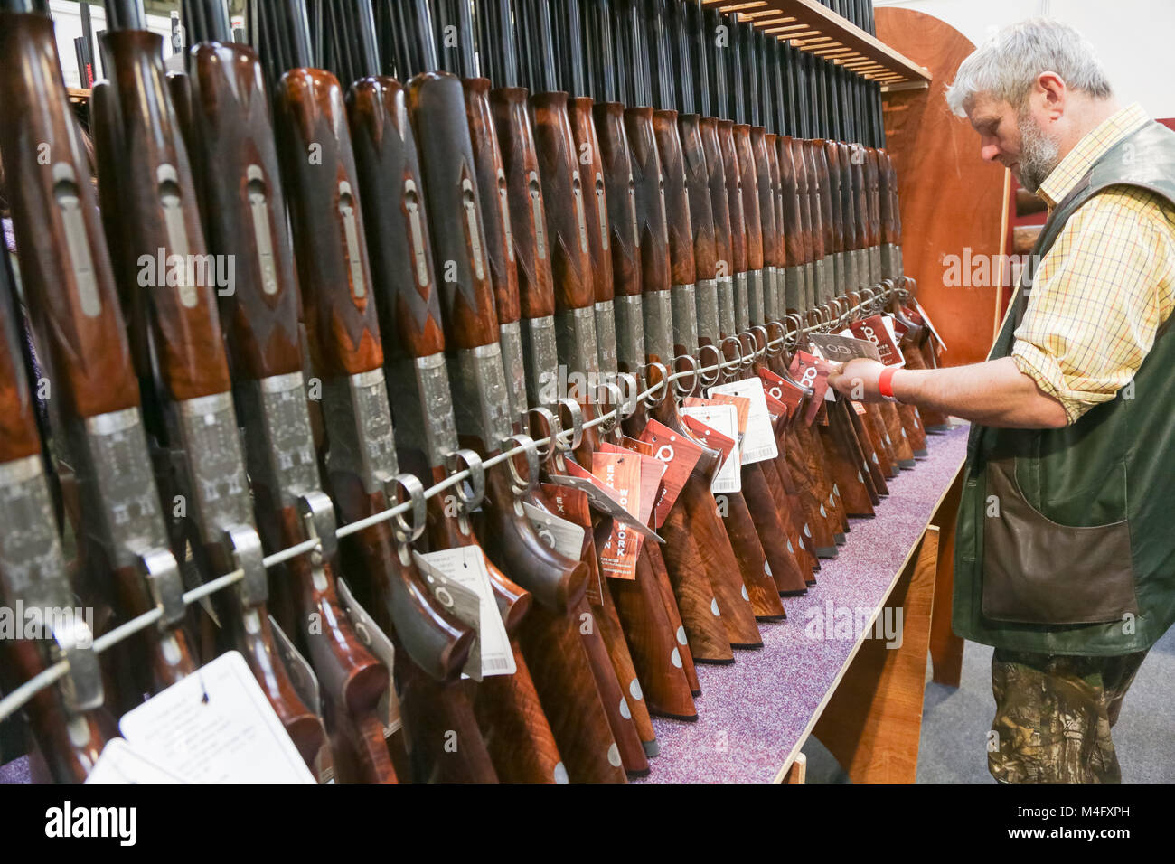 Man looking at a display of guns shotguns at a shooting show uk Stock ...