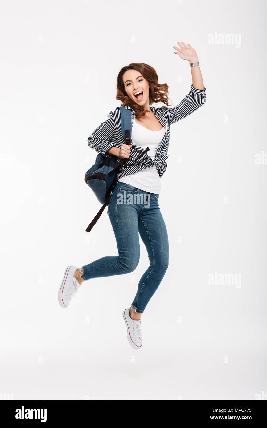 Photo of pretty beautiful young lady jumping isolated over white wall ...
