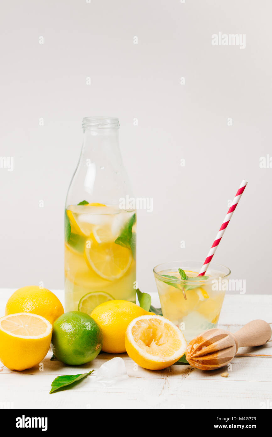Natural lemonade with lemon, lime and mint in a bottle with wooden ...