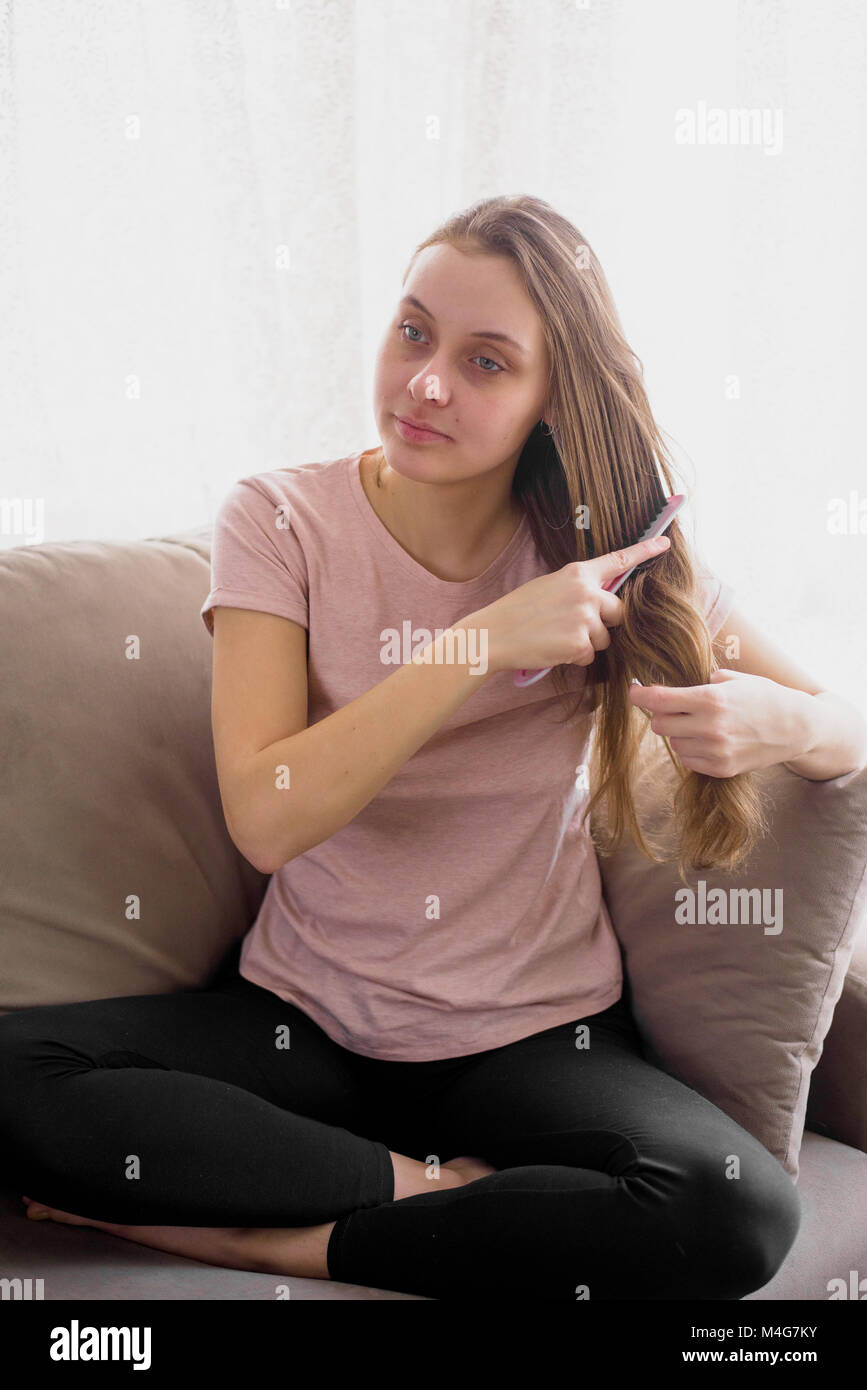 Portrait of attractive young woman sitting on couch at home Stock Photo ...