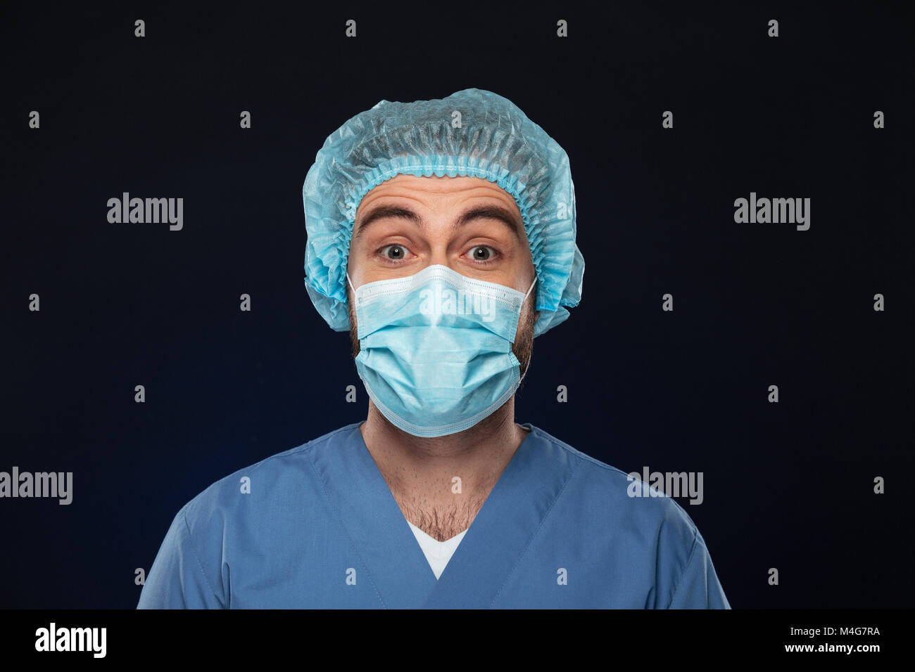 Close up portrait of a shocked male surgeon wearing face mask and ...
