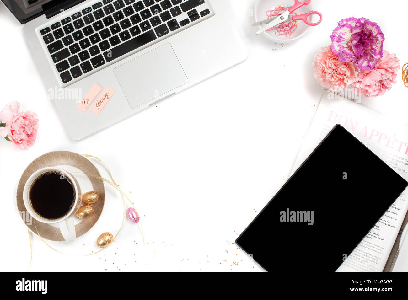 White, gold and pink womens office desk table with a lot of things on ...