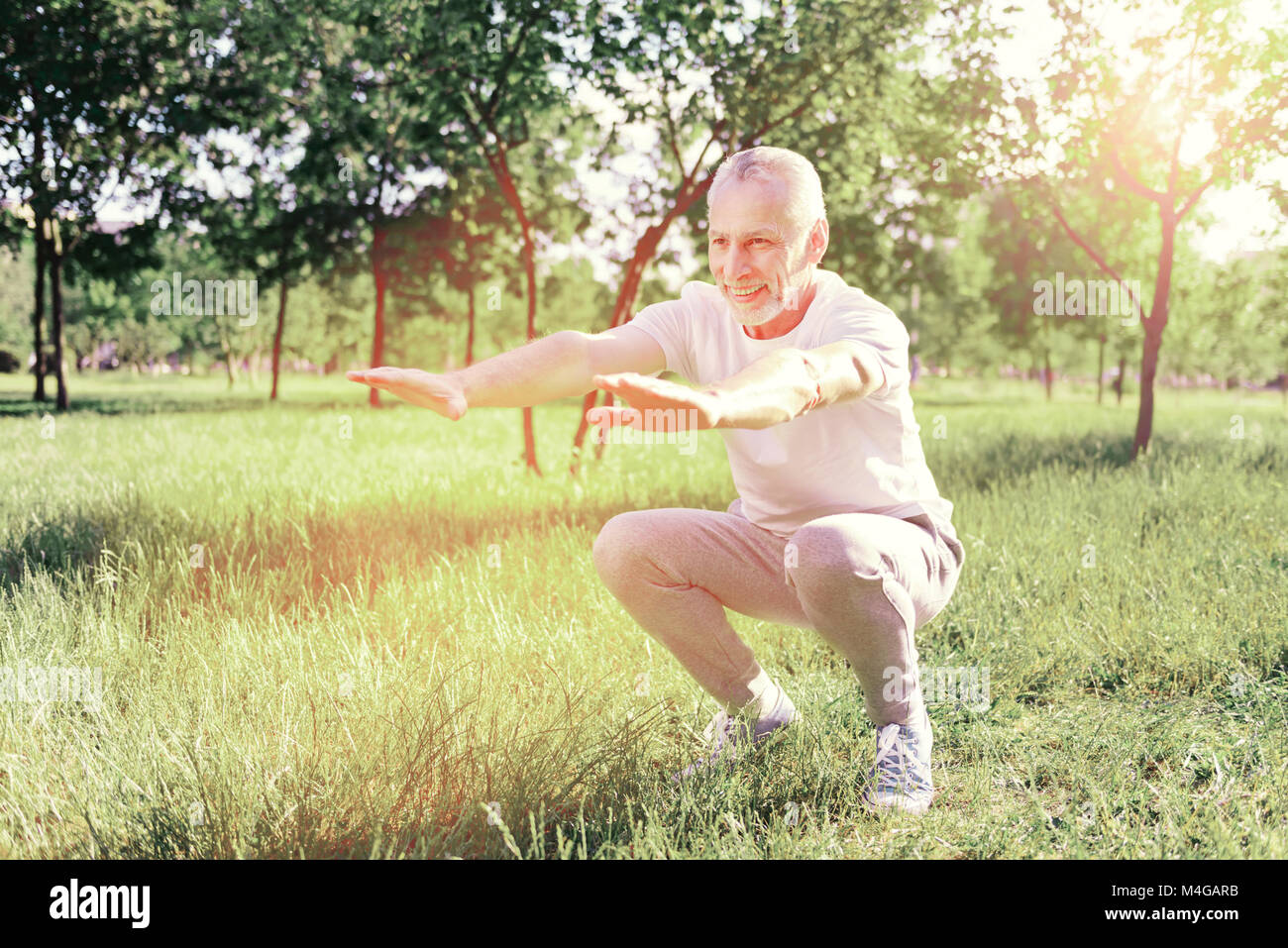Smiling man doing exercises outdoors Stock Photo - Alamy