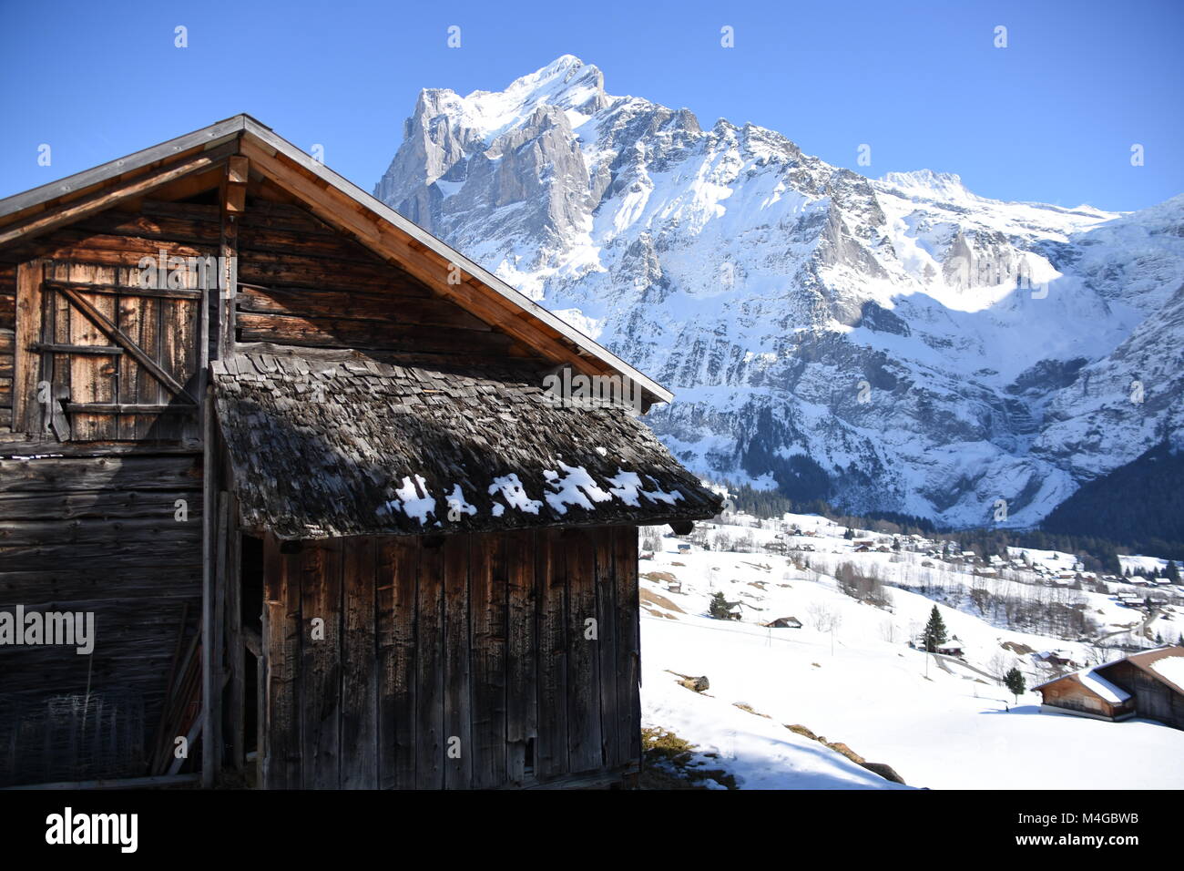 Wooden barn in winter and Wetterhorn in background, Grindelwald ...