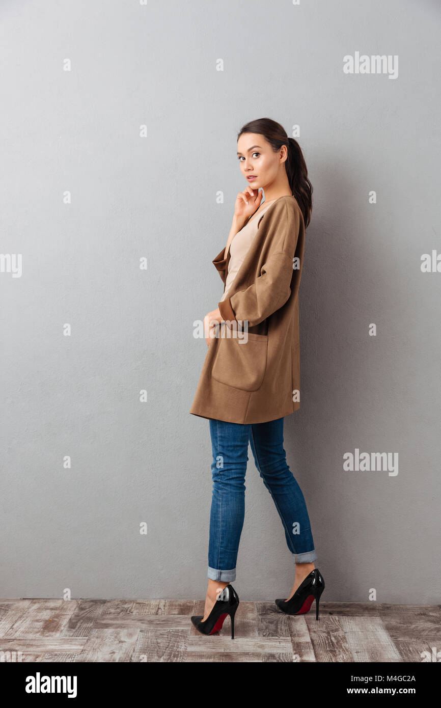 Side view full length of a pretty young asian woman posing while ...