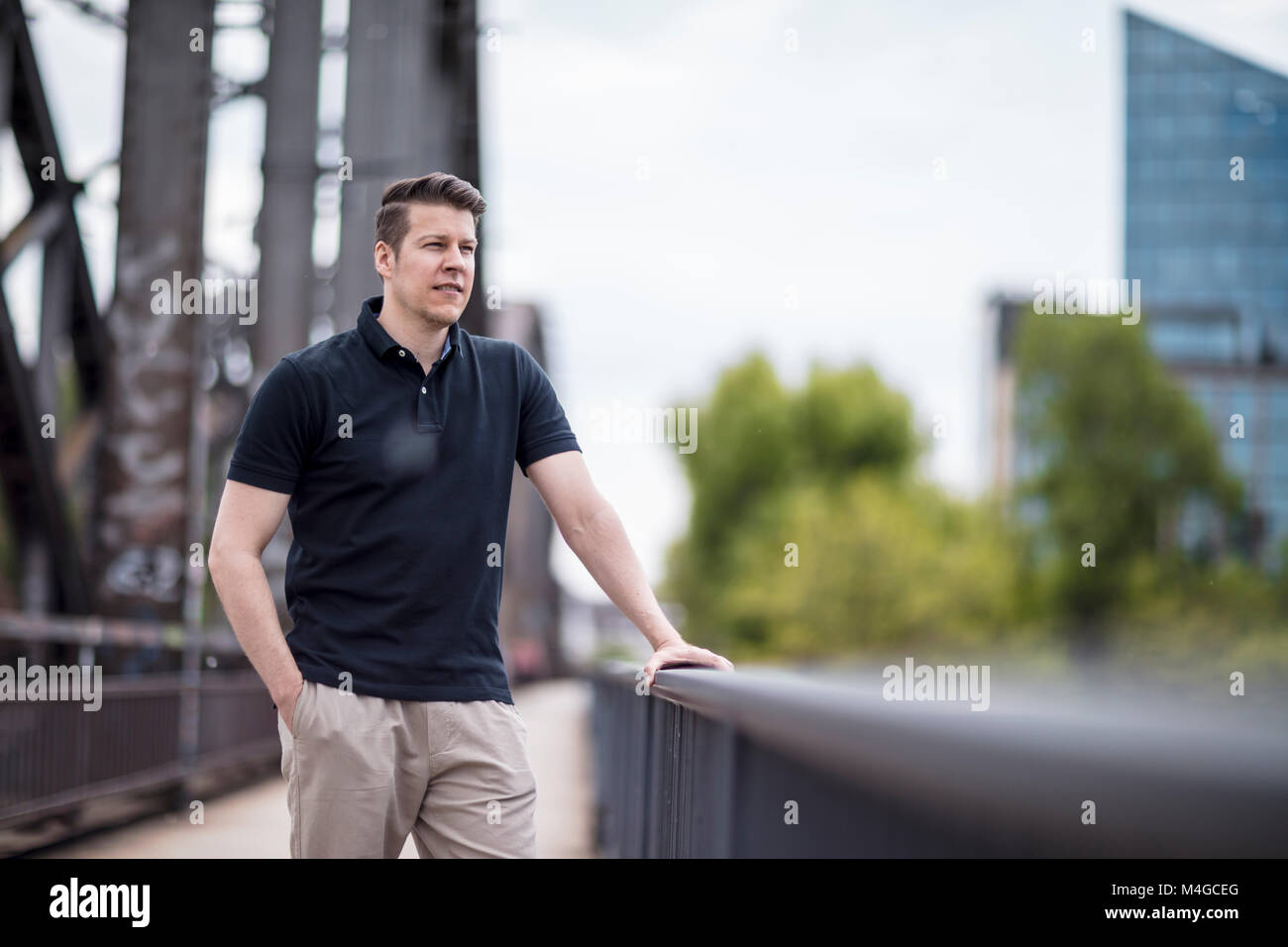 Portrait of a man posing on a city bridge. Medium shot Stock Photo - Alamy
