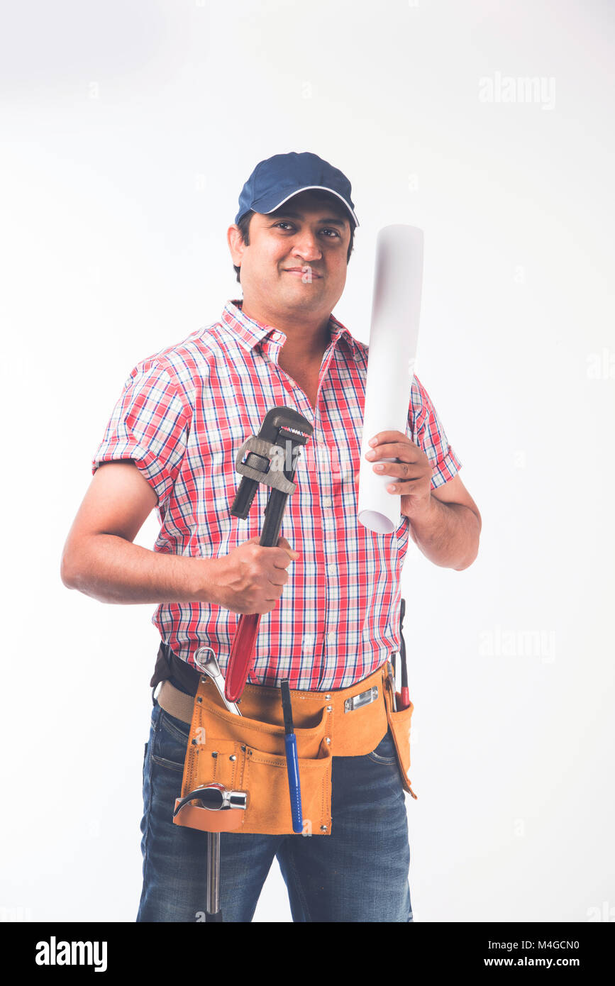 Indian plumber posing with Pipe wrench or plumbing spanner, standing ...