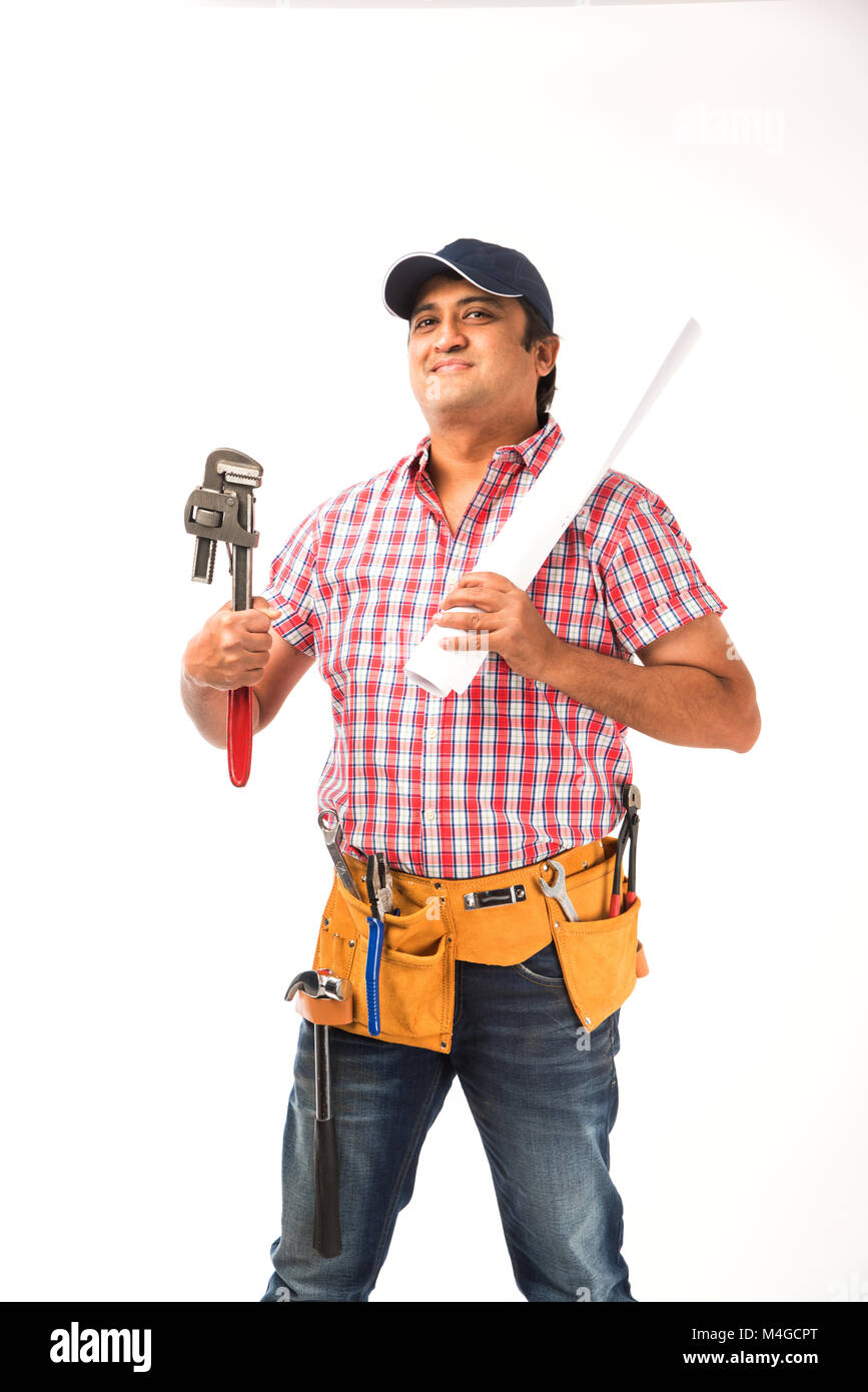 Indian plumber posing with Pipe wrench or plumbing spanner, standing ...