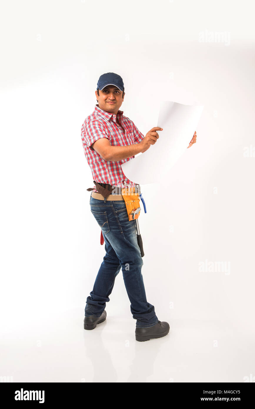 Indian plumber posing with Pipe wrench or plumbing spanner, standing ...