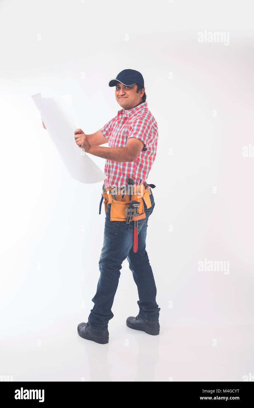 Indian plumber posing with Pipe wrench or plumbing spanner, standing ...