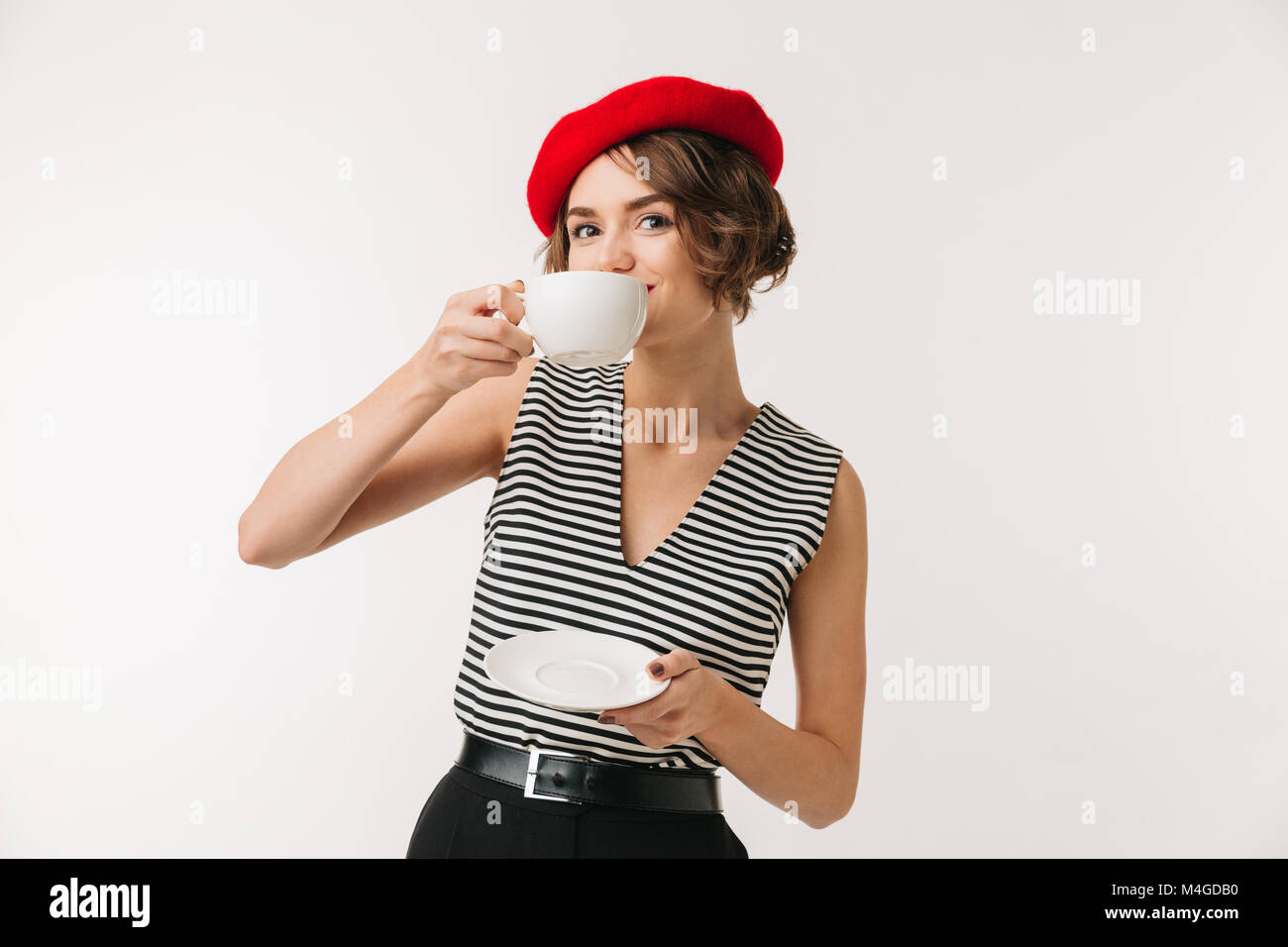 Portrait of a beautiful woman wearing red beret drinking tea from cup ...