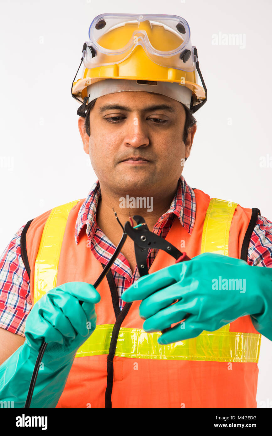 Indian electrician engineer in action with wire cutter, drilling ...