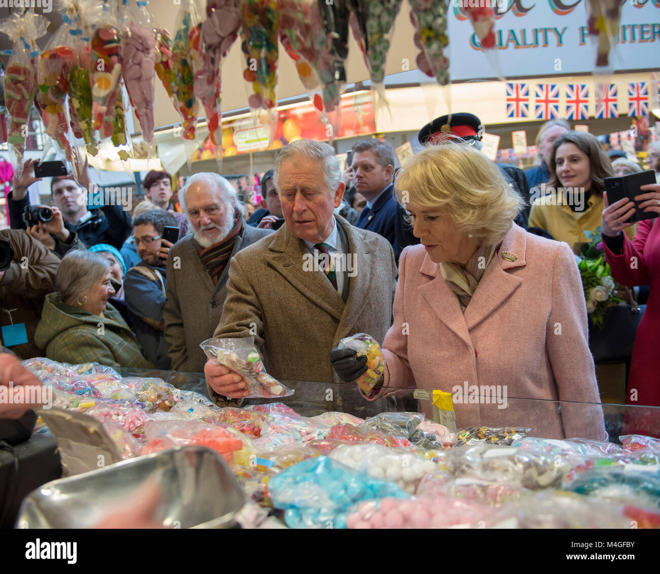 The Prince of Wales and the Duchess of Cornwall are given sweets during ...