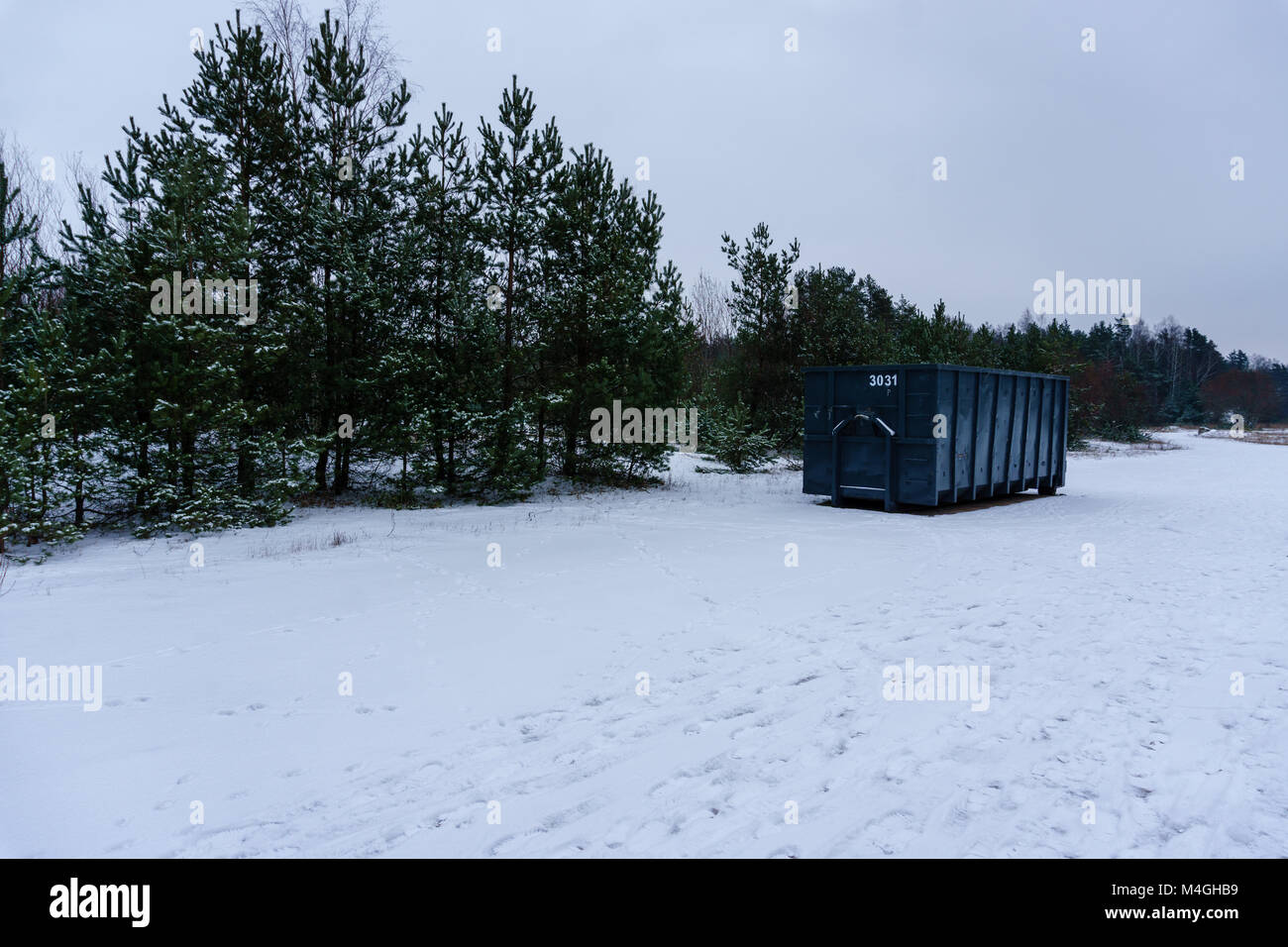 Trash bin at the side of street in winter with lip garbage container ...