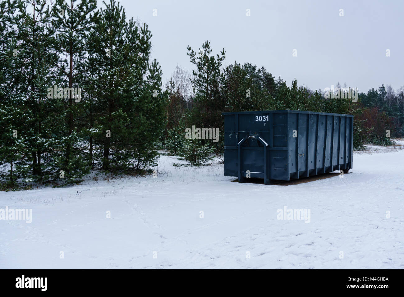 Trash bin at the side of street in winter with lip garbage container ...