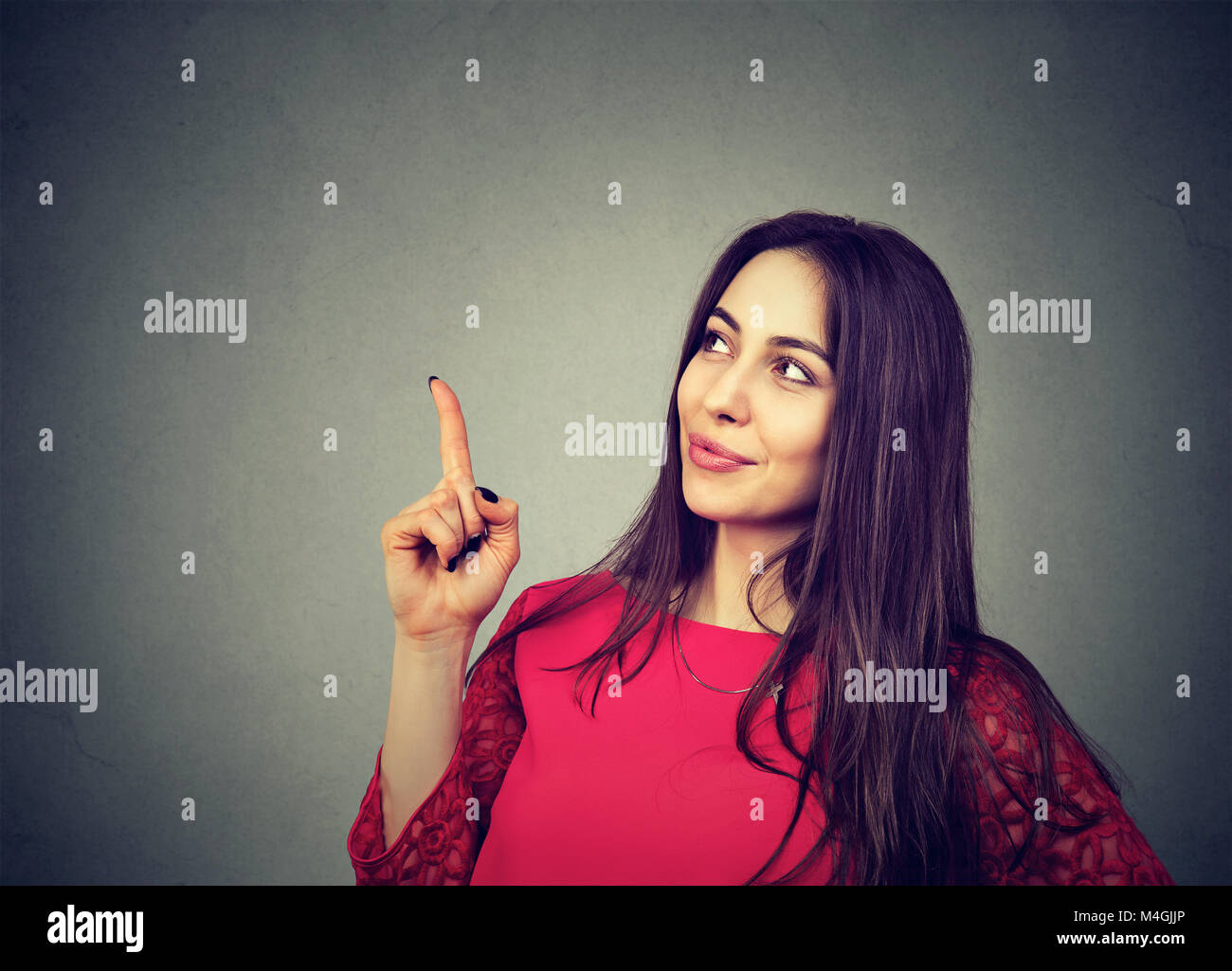 Beautiful young model pointing up showing something while posing ...