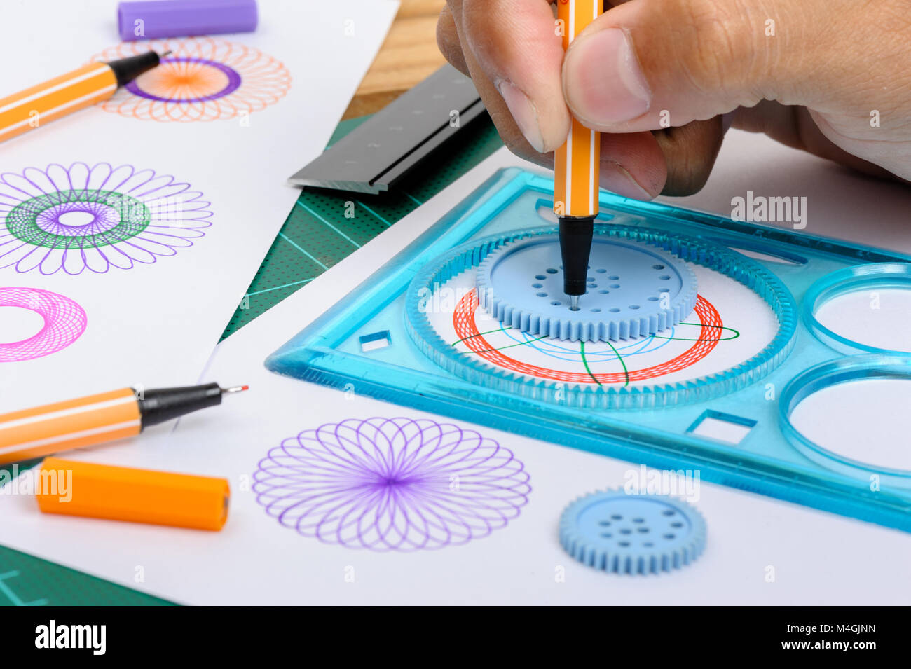 Drawing the spirograph pattern with spirograph kit Stock Photo - Alamy