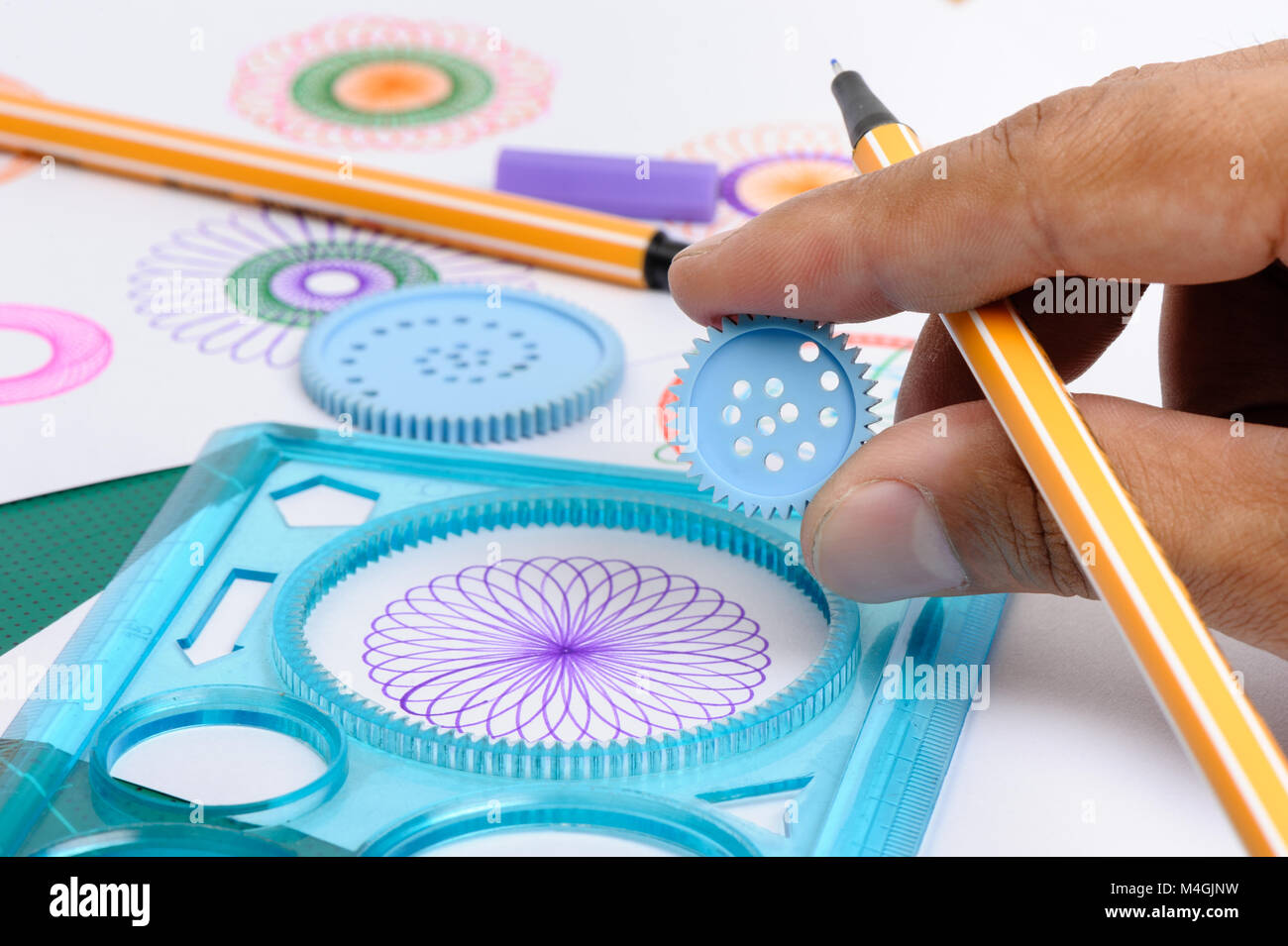Drawing the spirograph pattern with spirograph kit Stock Photo - Alamy