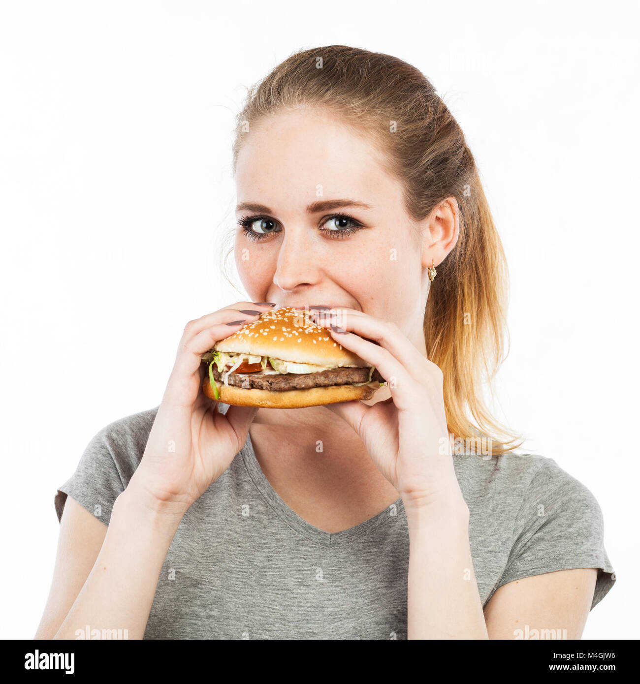 Portrait of a cute young woman eating a burger, isolated on white Stock ...