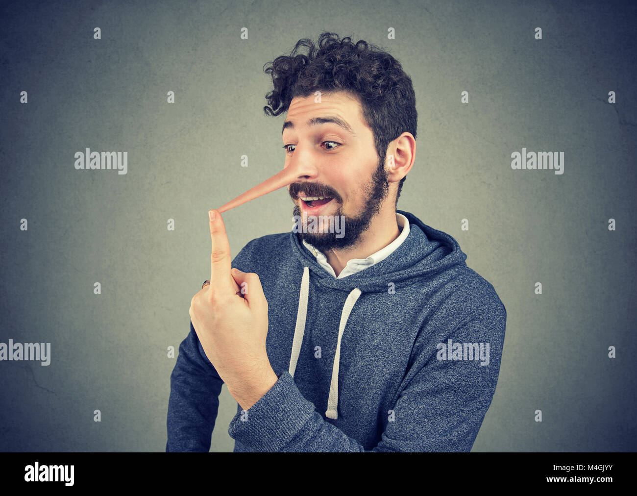 Man with long nose isolated on gray wall background. Liar concept ...